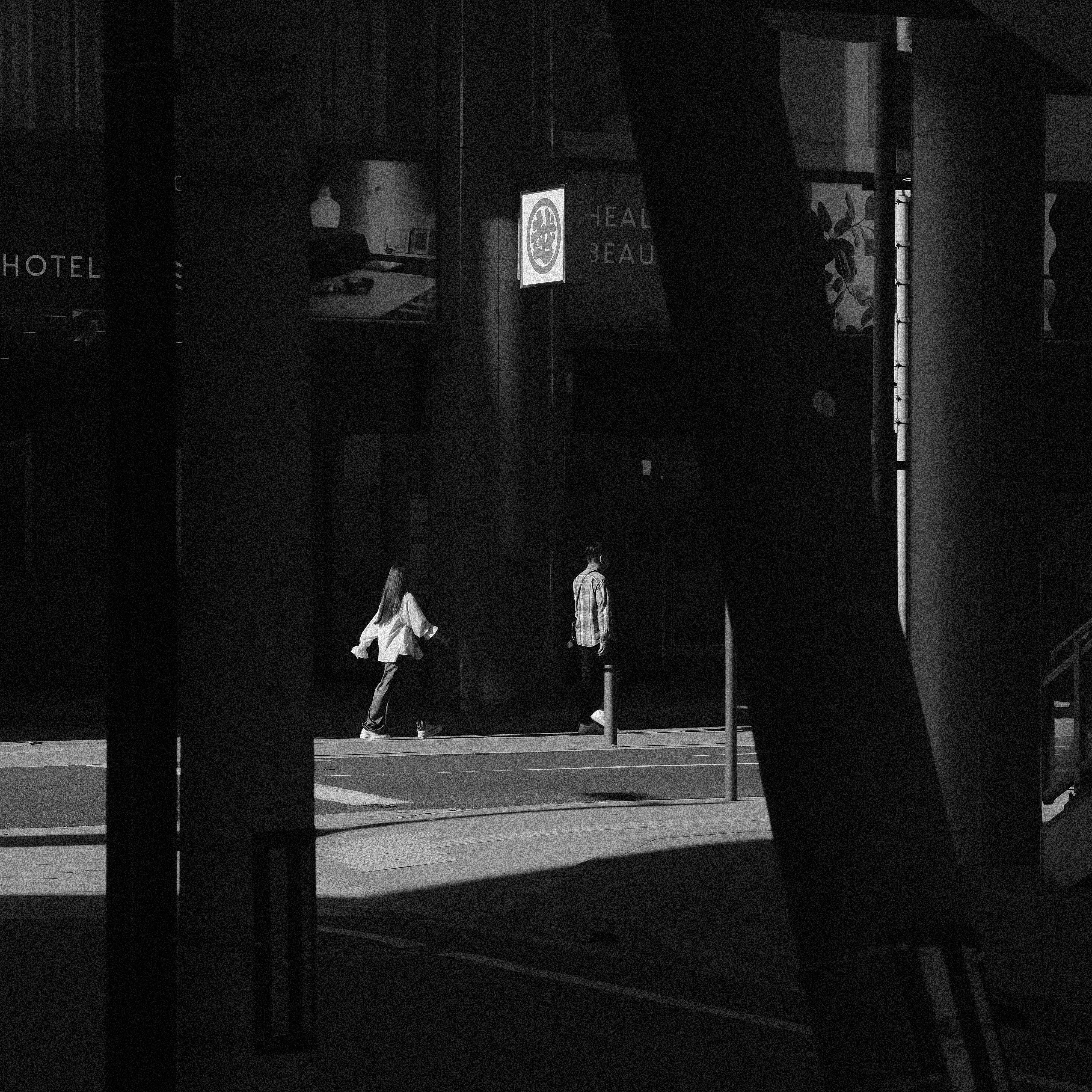 Shadowed Columns, Quiet Walk: A Street Scene Through Concrete Arches