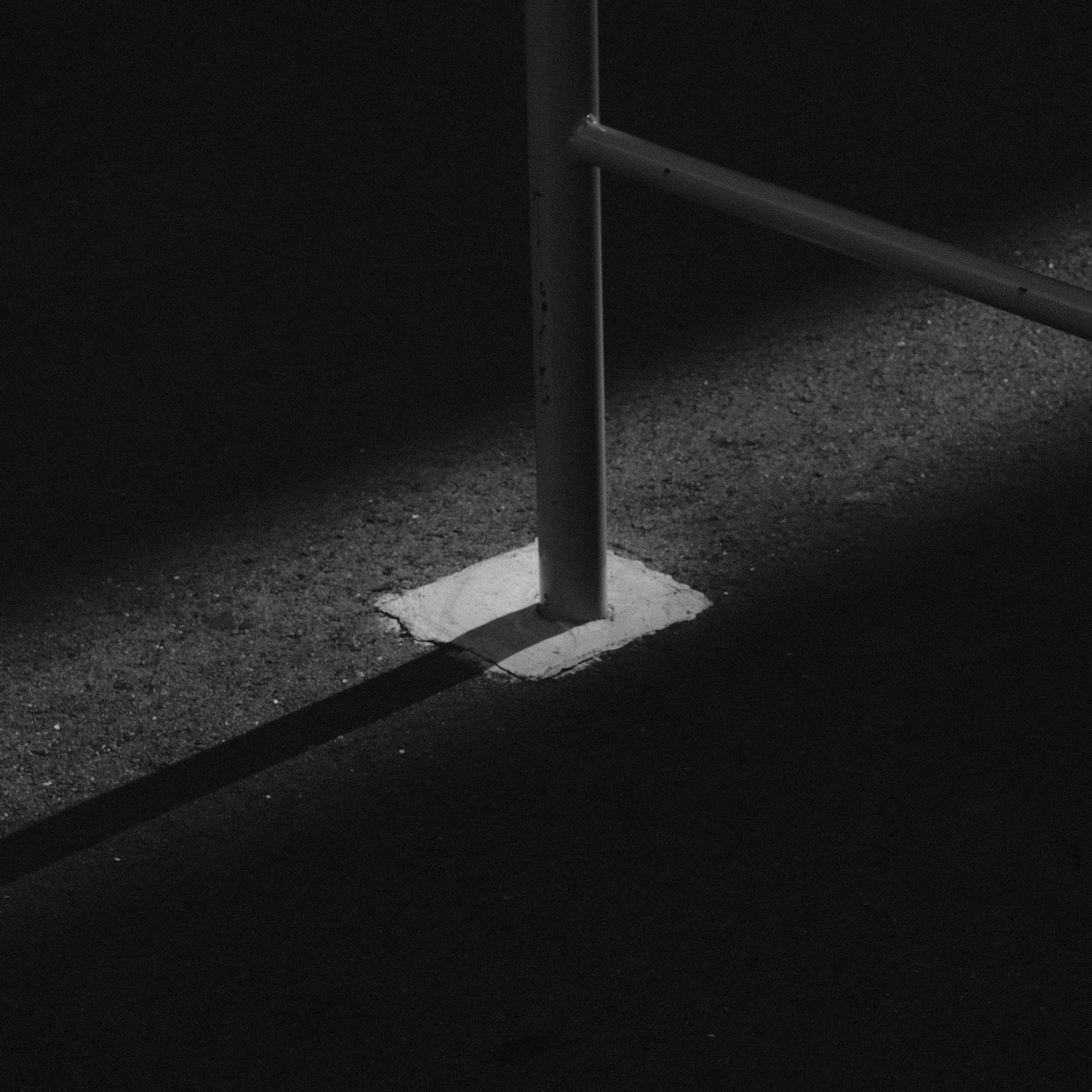 Shadowed Rail Against the Street: A Minimal Moment in Gray