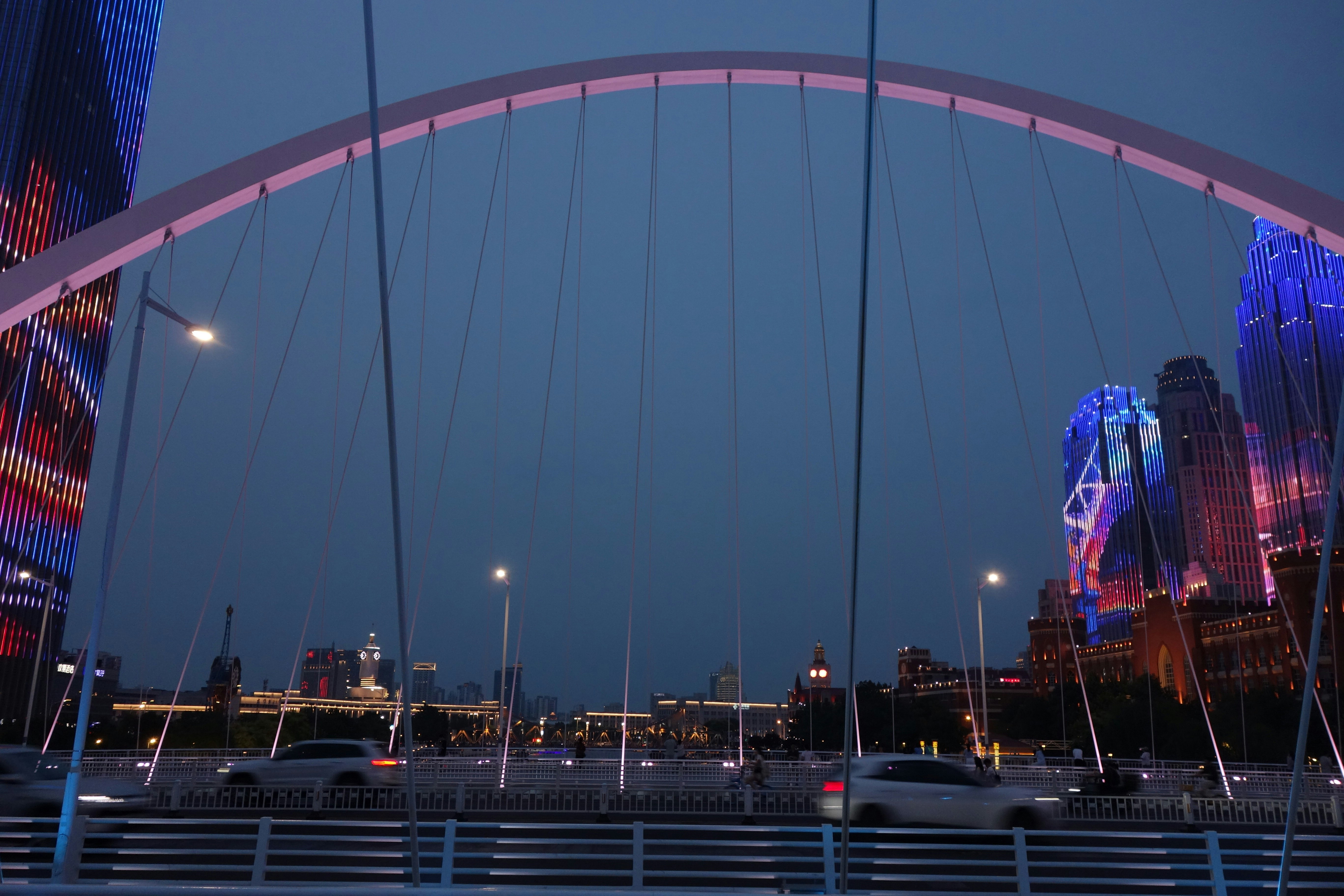 Suspended Arc Over a City Wake: Neon Bridge at Dusk