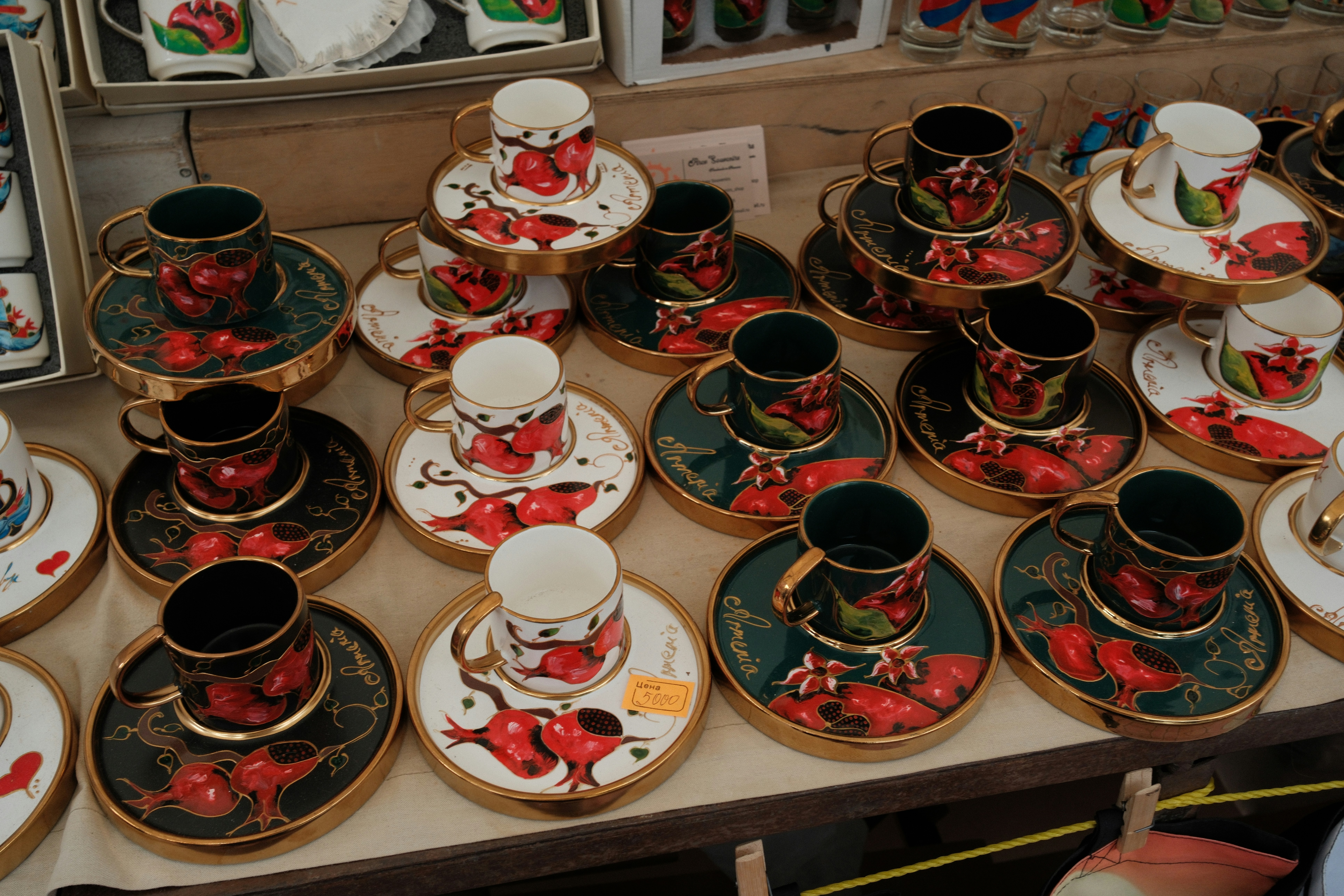 Fruit motif porcelain cups and saucers neatly stacked on a market stall