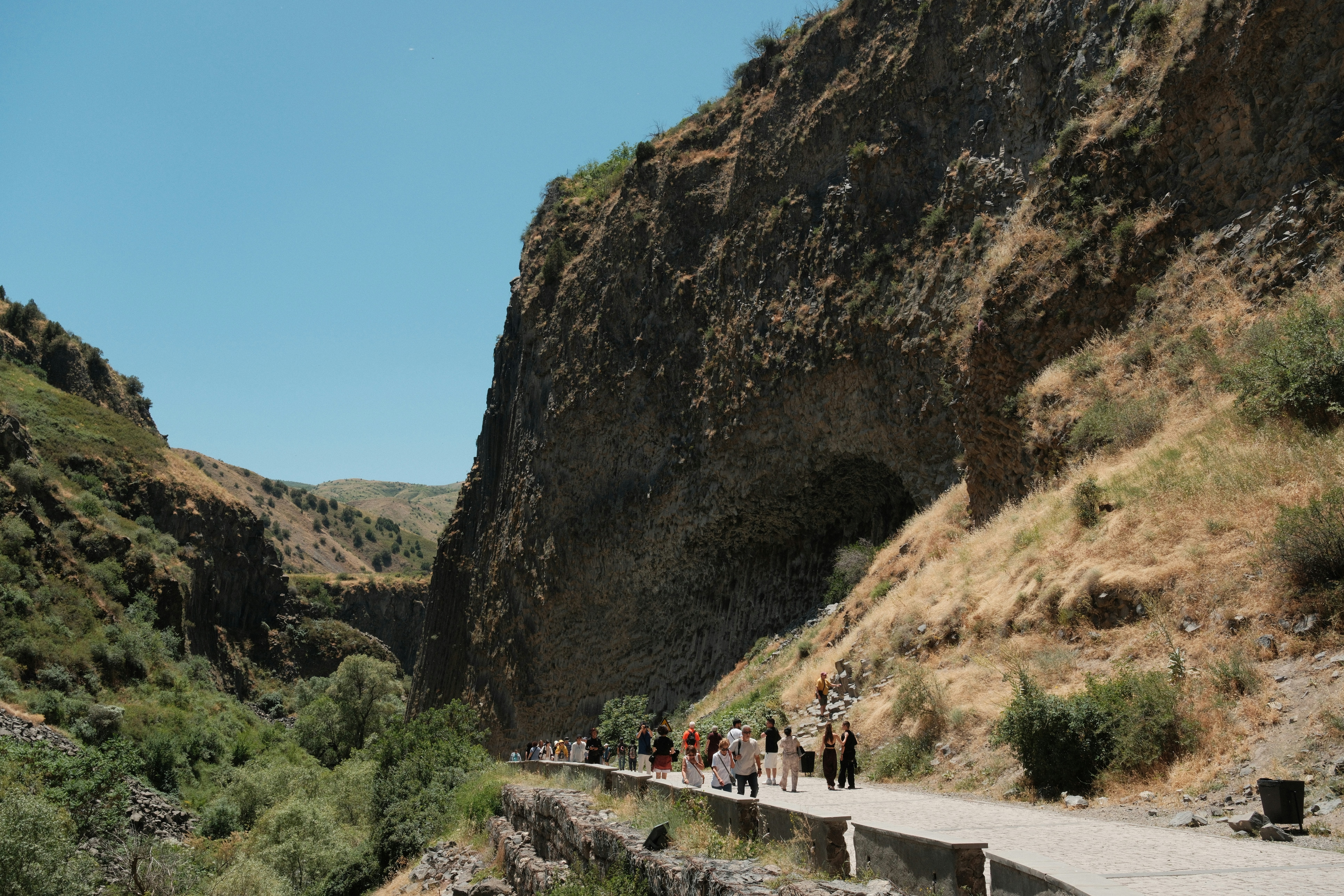 Hikers on a Narrow Path Carved Along a Cliff Face