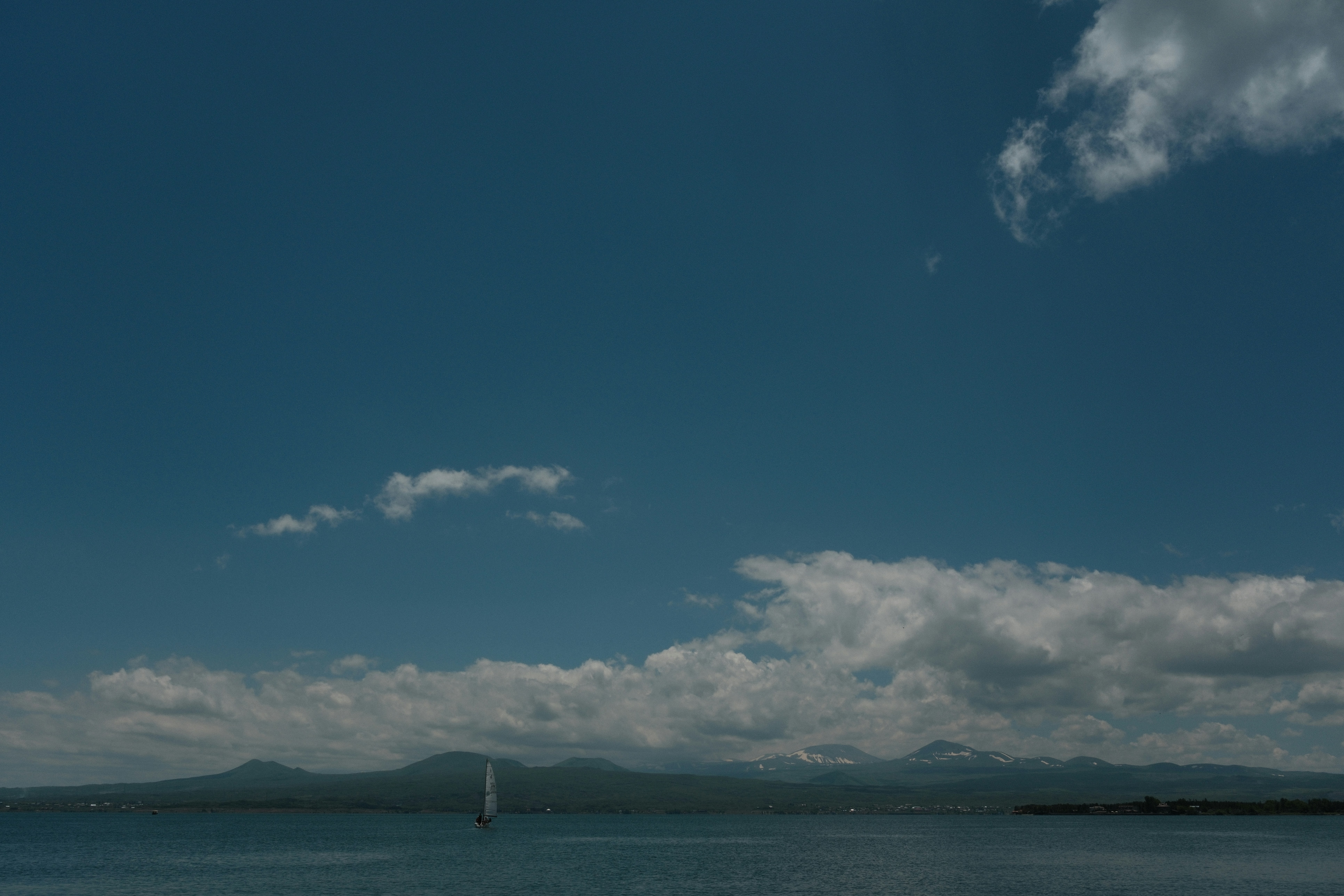 Horizon Breath: A Sail at Dusk Over Quiet Waters