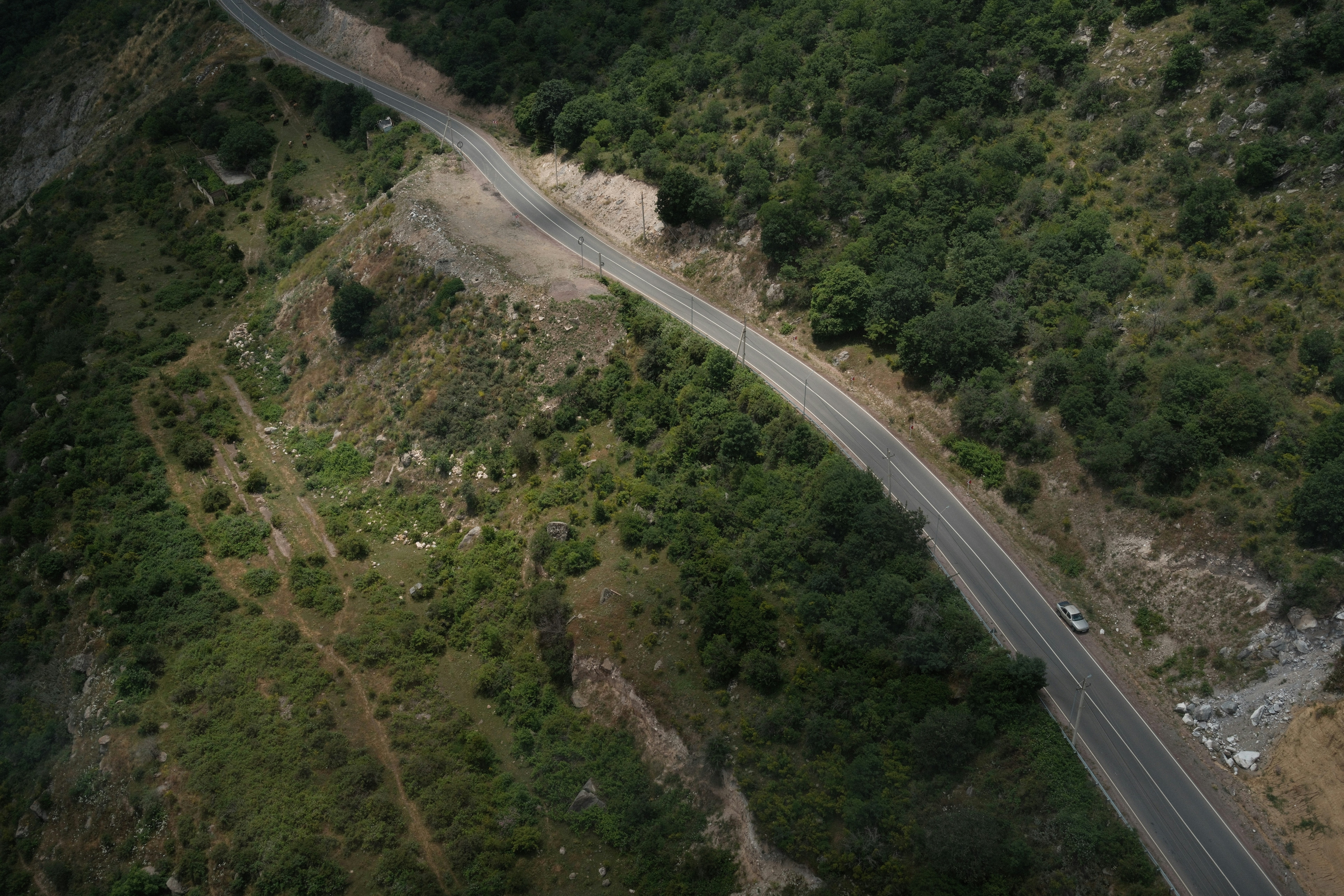 A Quiet Bend: A Curved Mountain Road Cutting Through Verdant Terrain