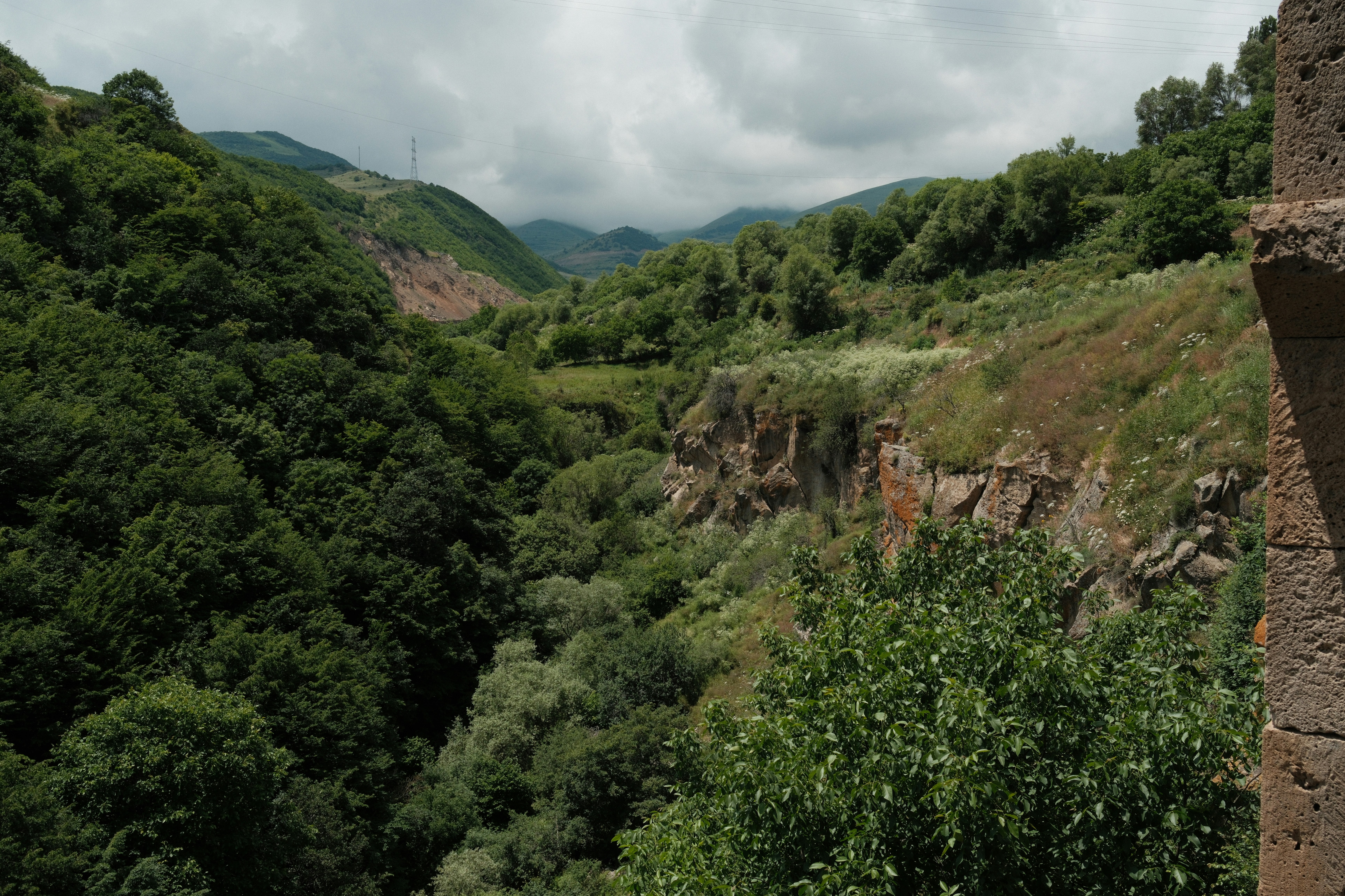 Sunlit Gorge Overlook: Verdant Valleys Amidst Carved Cliffs