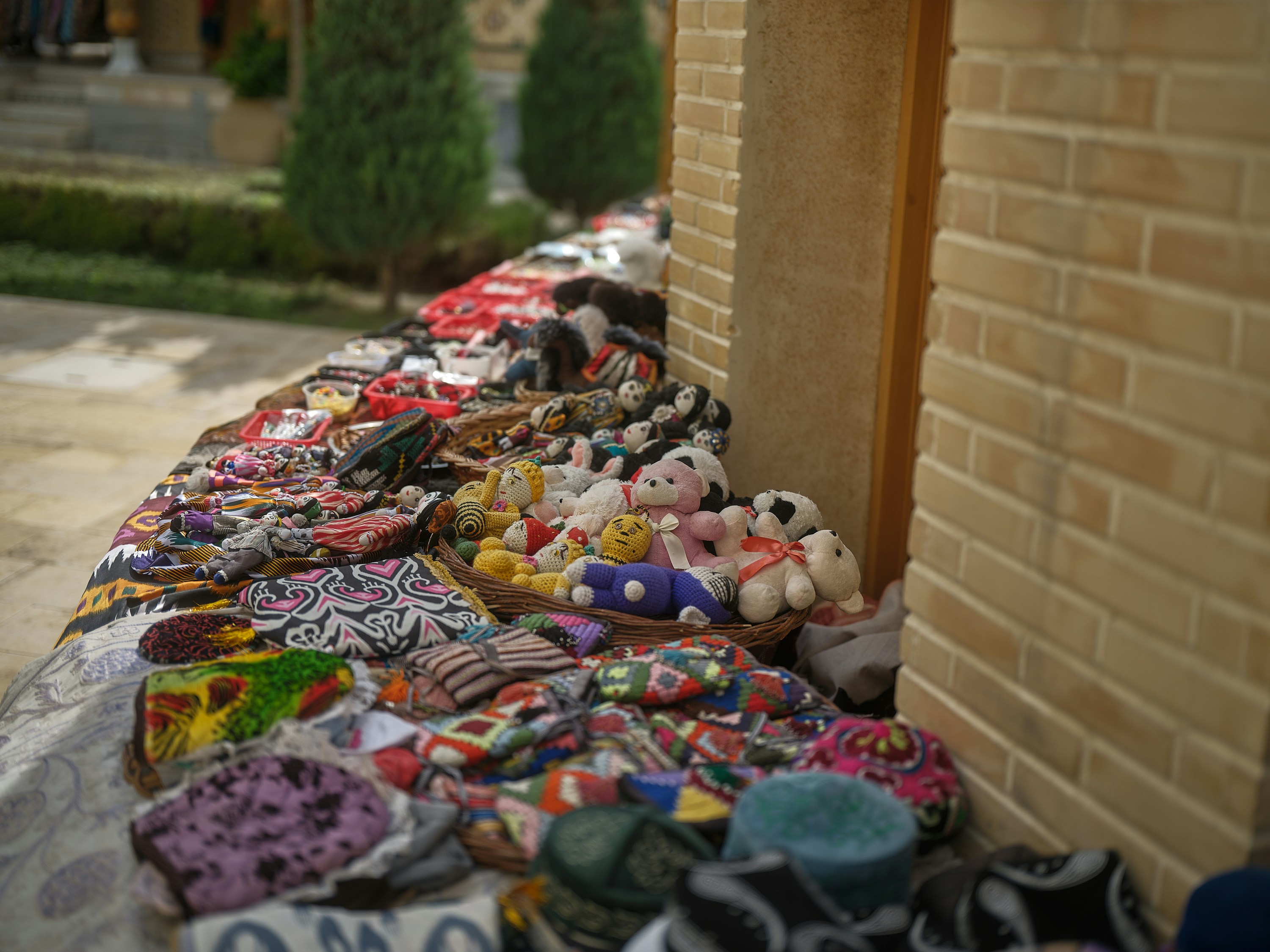 Row of plush treasures lining a sunlit brick wall