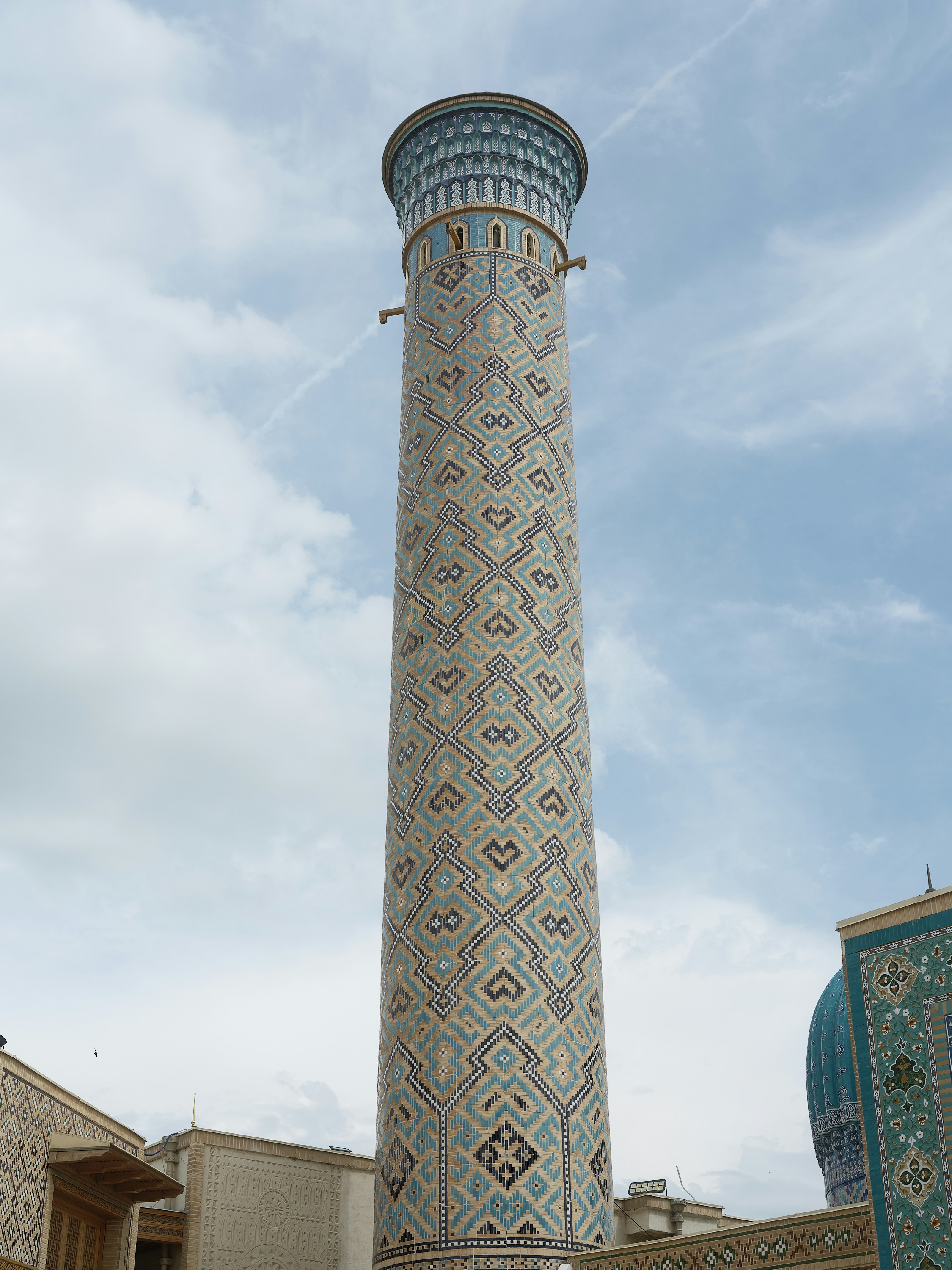 Geometric Pillar: A Tiled Column Reaching Toward a Cloudy Sky