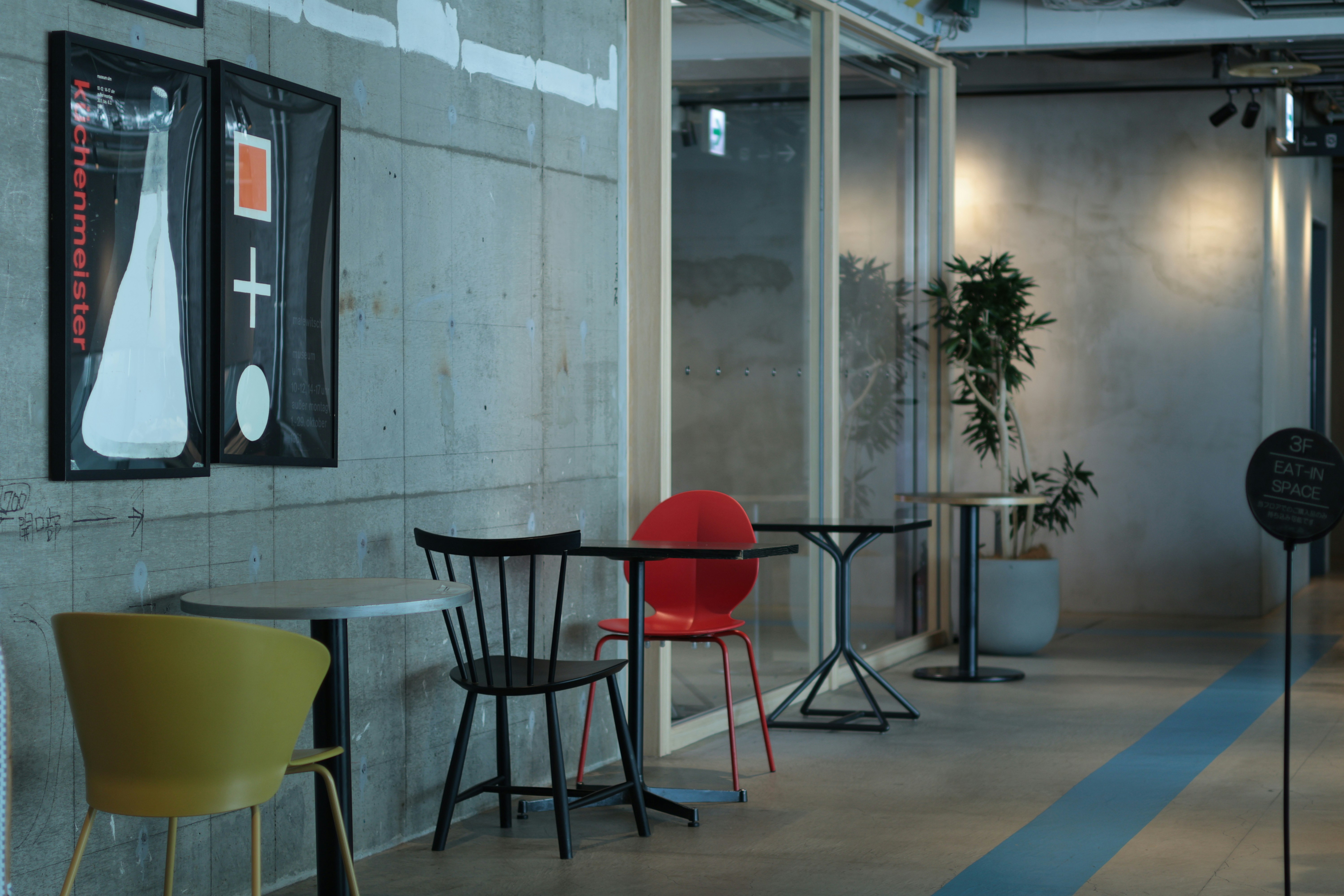 Muted Café Geometry: Red Chair Among Concrete Walls