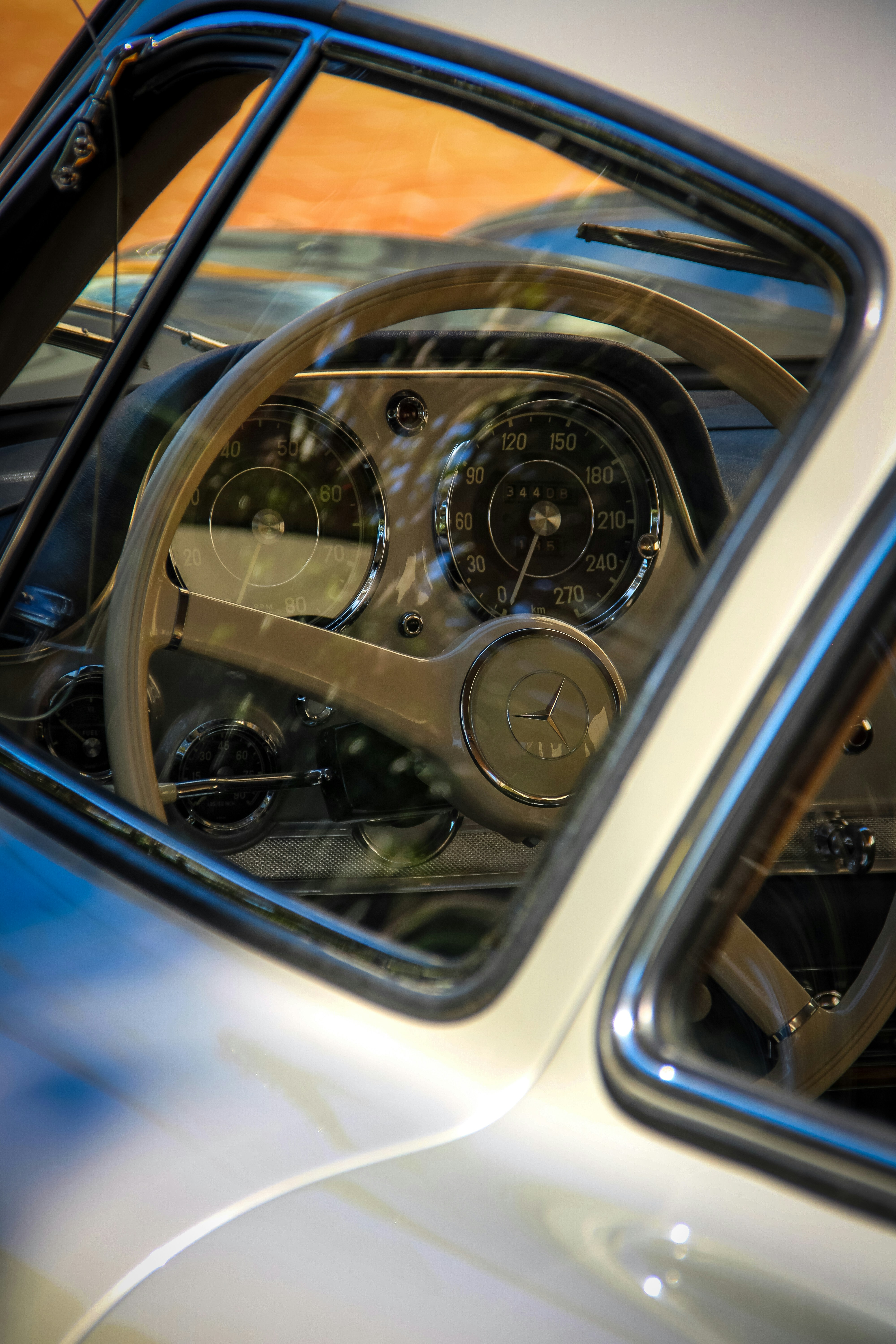 Chrome steering wheel glimpse: a vintage car cockpit in motion