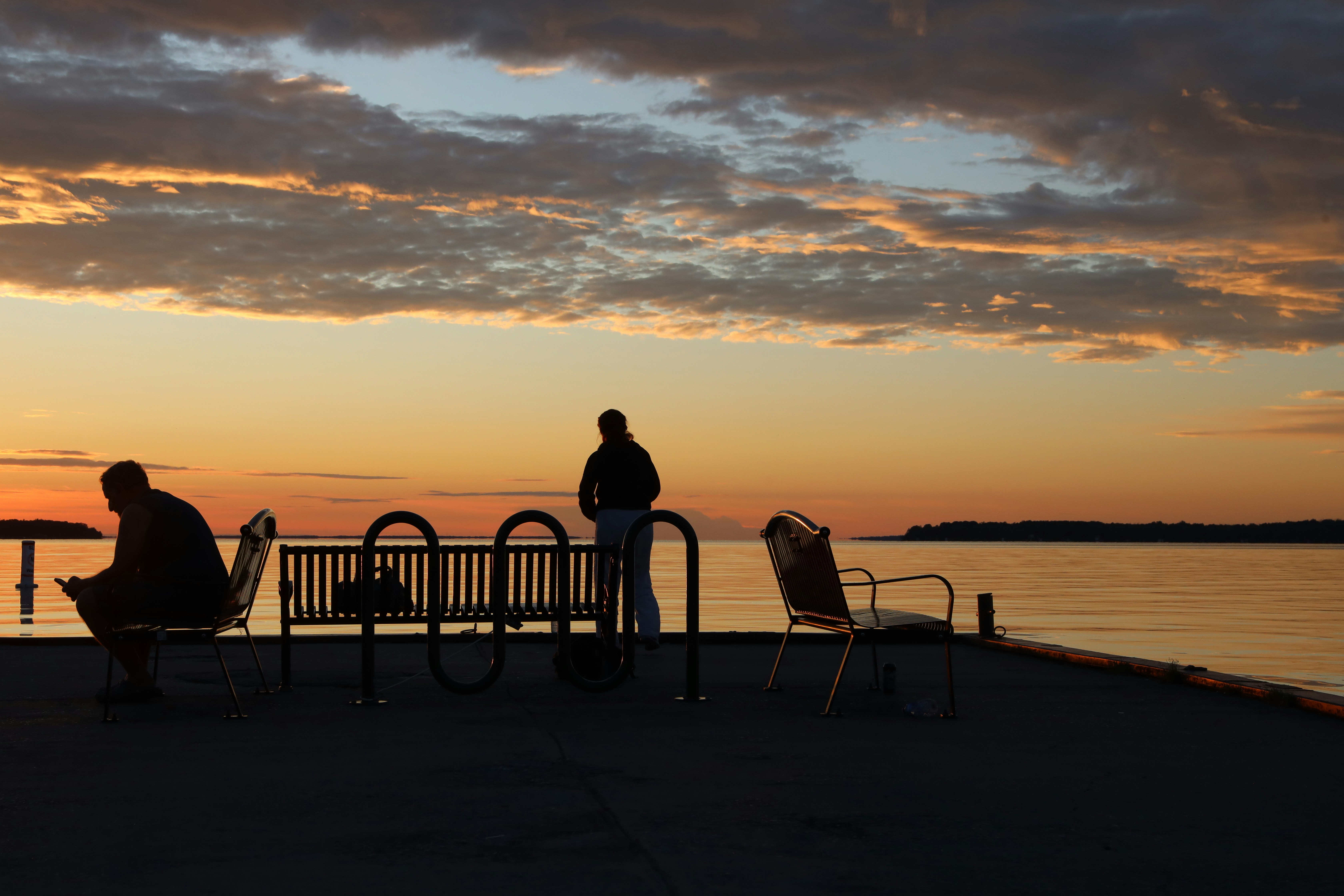 Silhouetted Figures at Sunset Pier