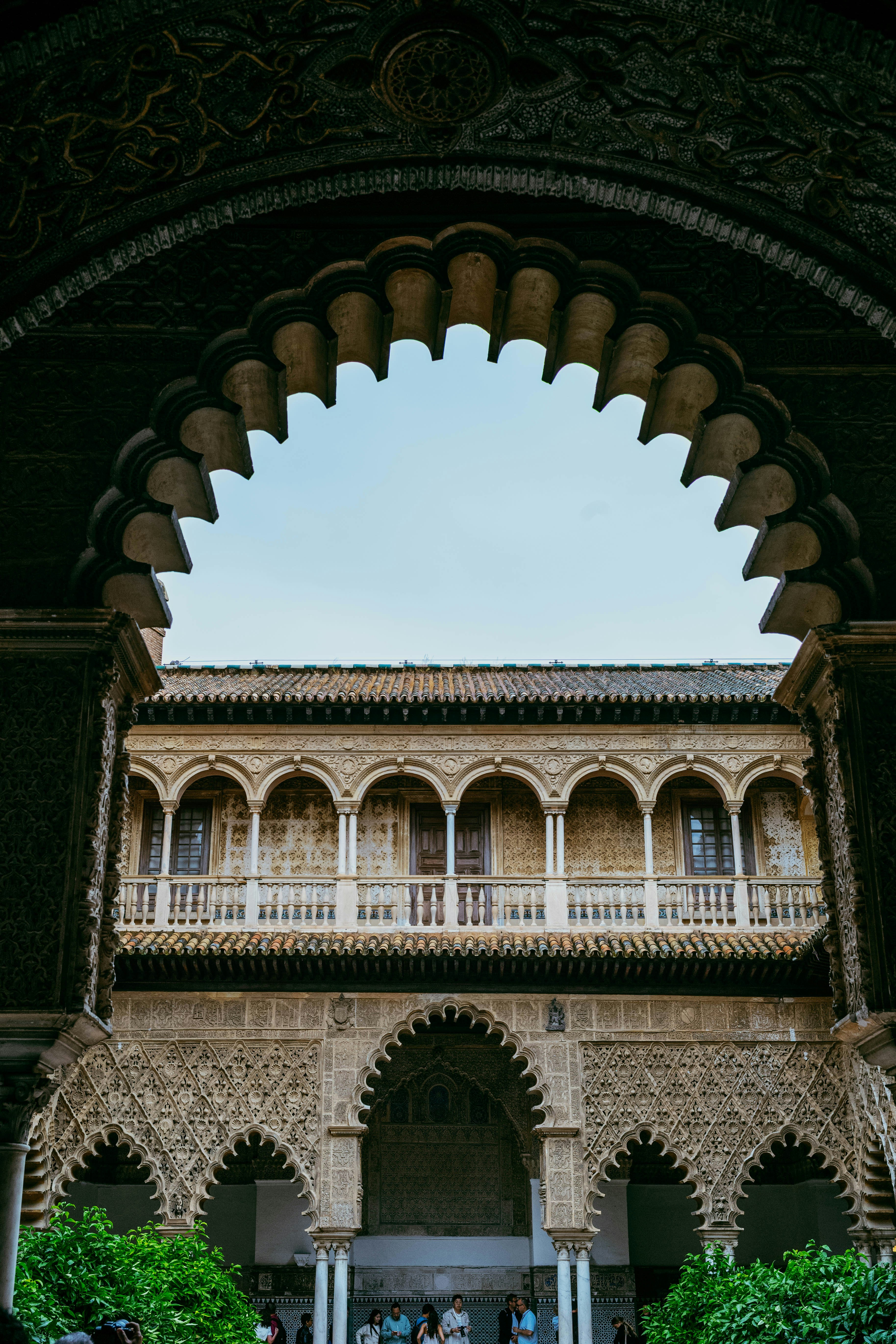 ArchwayVista: Carved Moorish Arch Framing a Skyward Courtyard