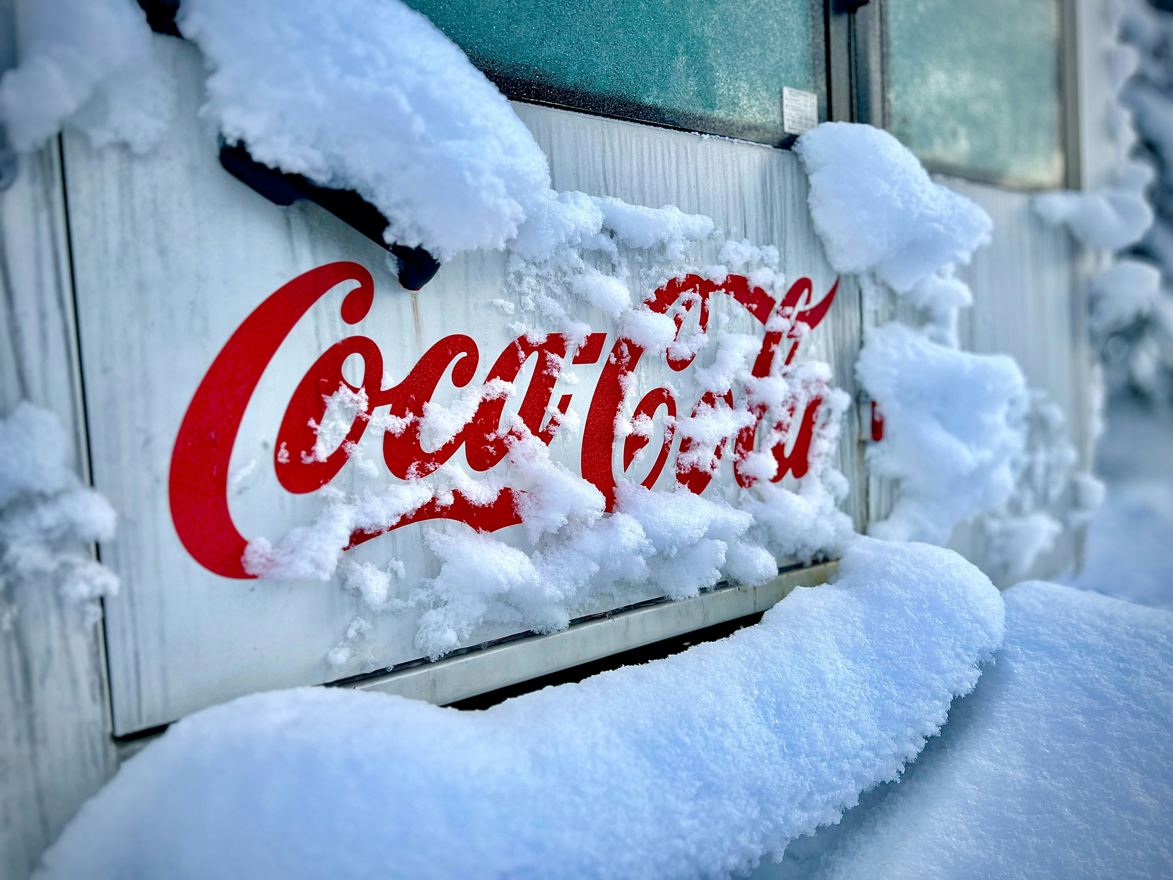 Frozen Coca-Cola Sign Beneath a Snowy Window