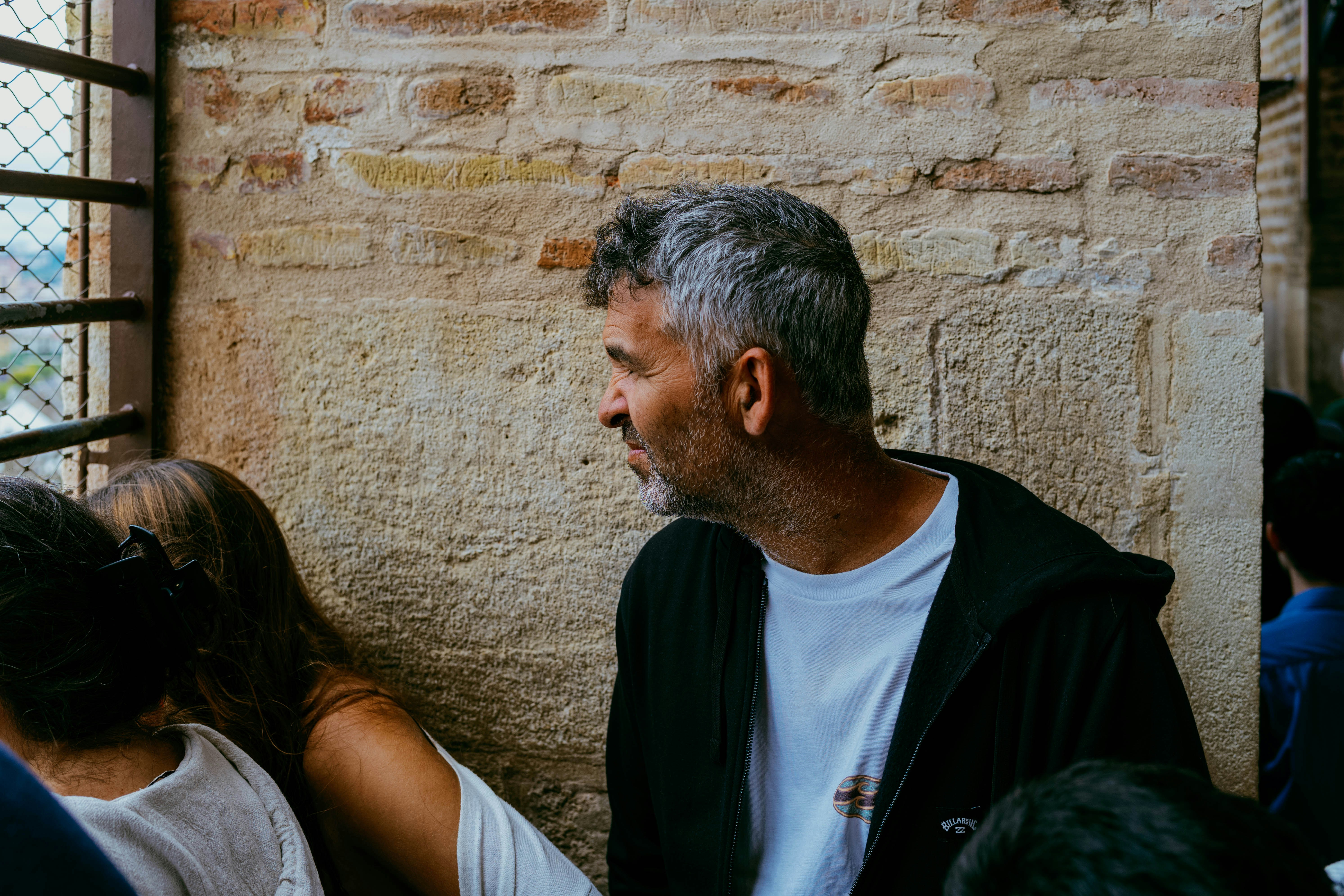 Muted Conversation by Sunlit Stone Wall