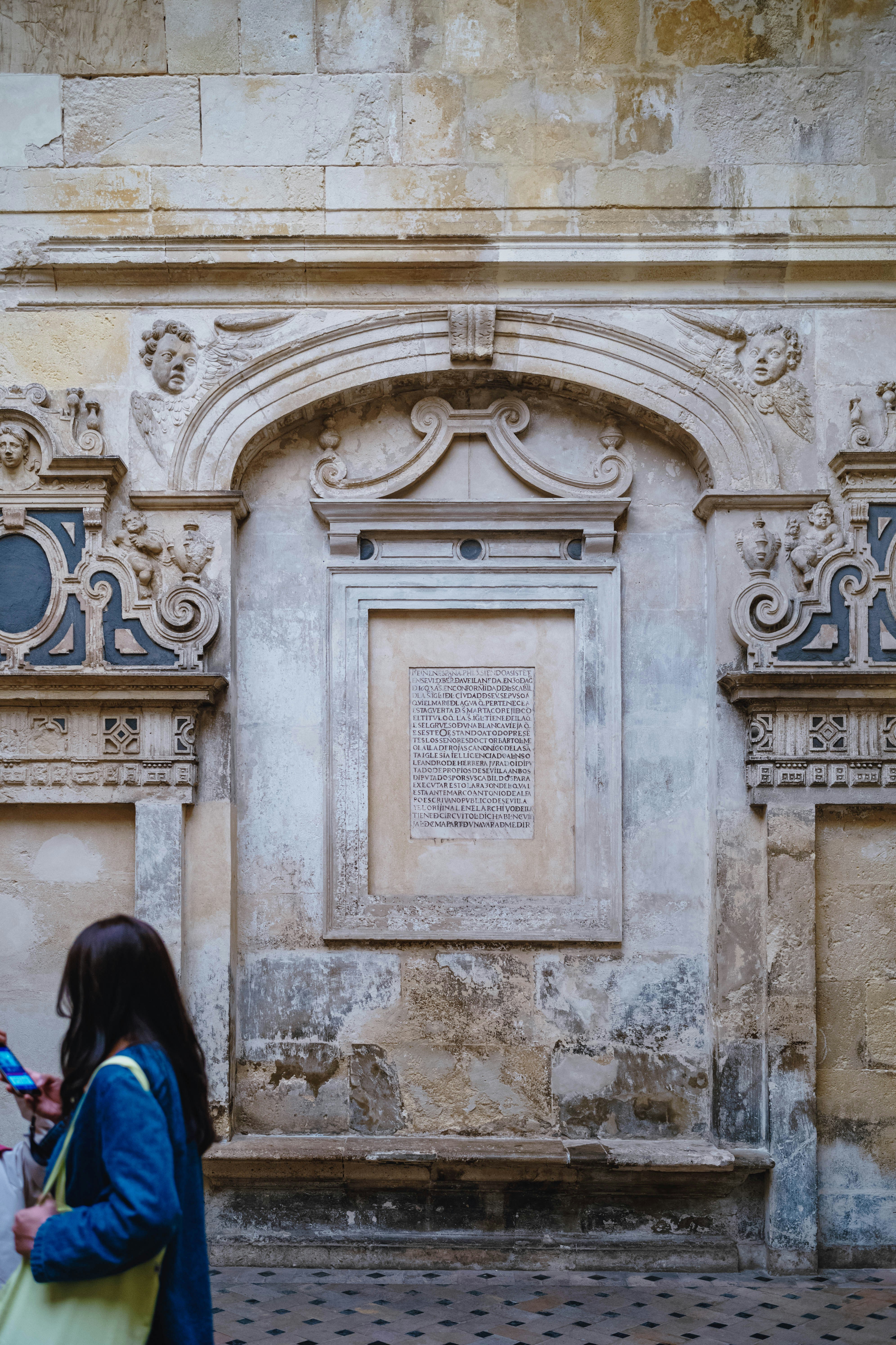Weathered Facade with Ornate Archway and a Quiet Visitor
