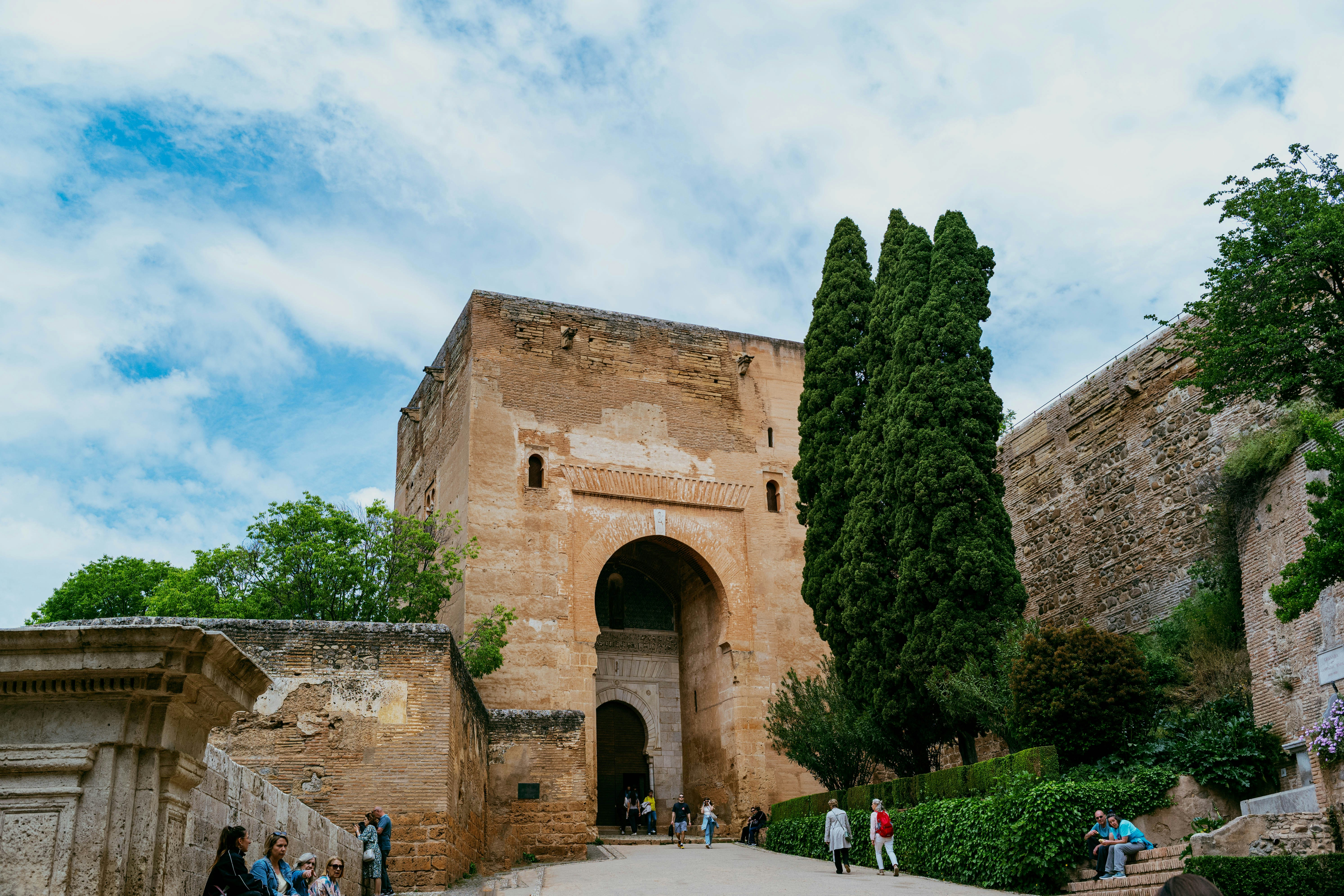 Gatehouse at Dawn: People and Cypressen Framing an Ancient Arbor