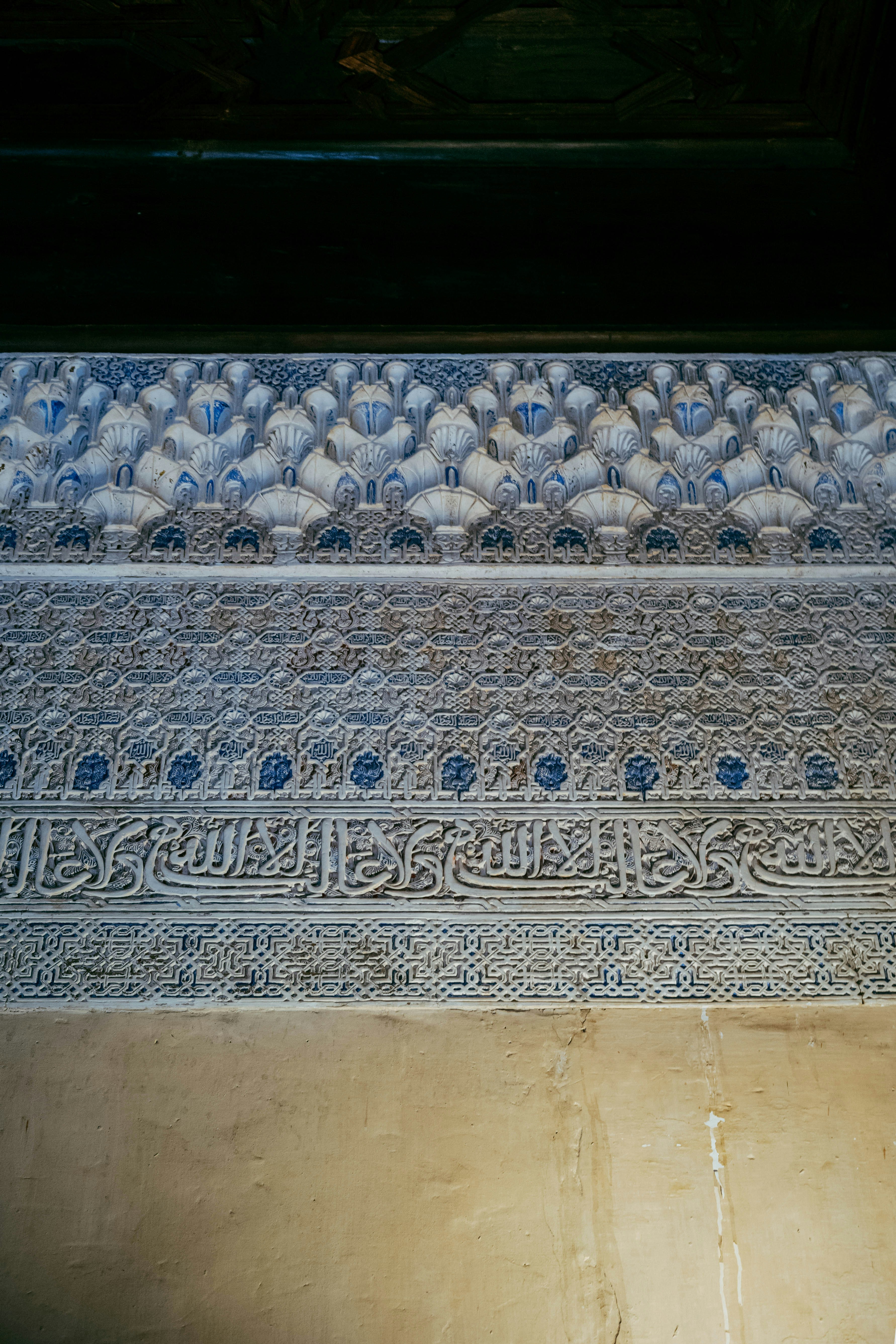 Carved Stone Frieze: Intricate Reliefs and Arabic Script in Quiet Light