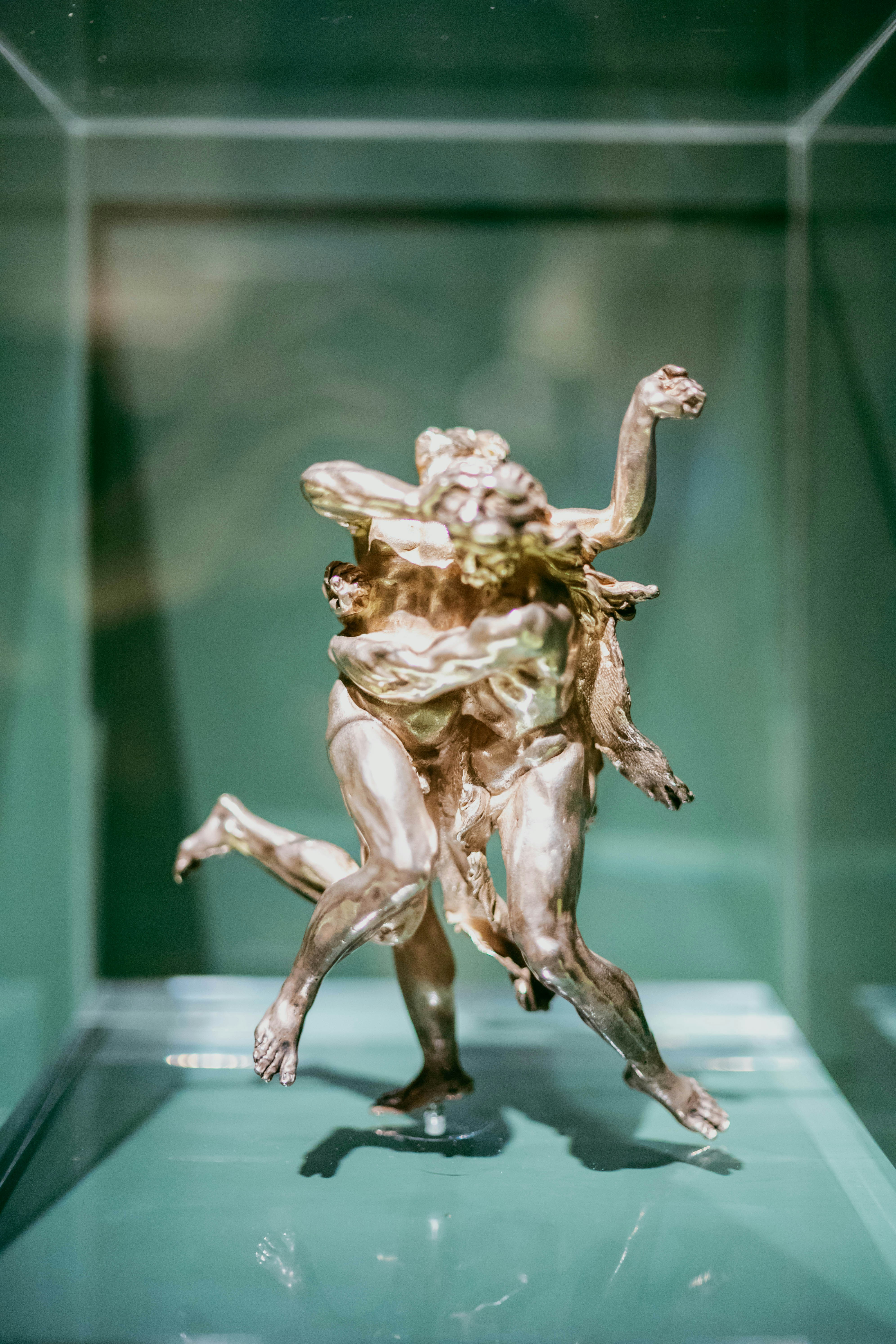 Bronze Wrestlers in Glass Case: A Moment Captured in Quiet Motion