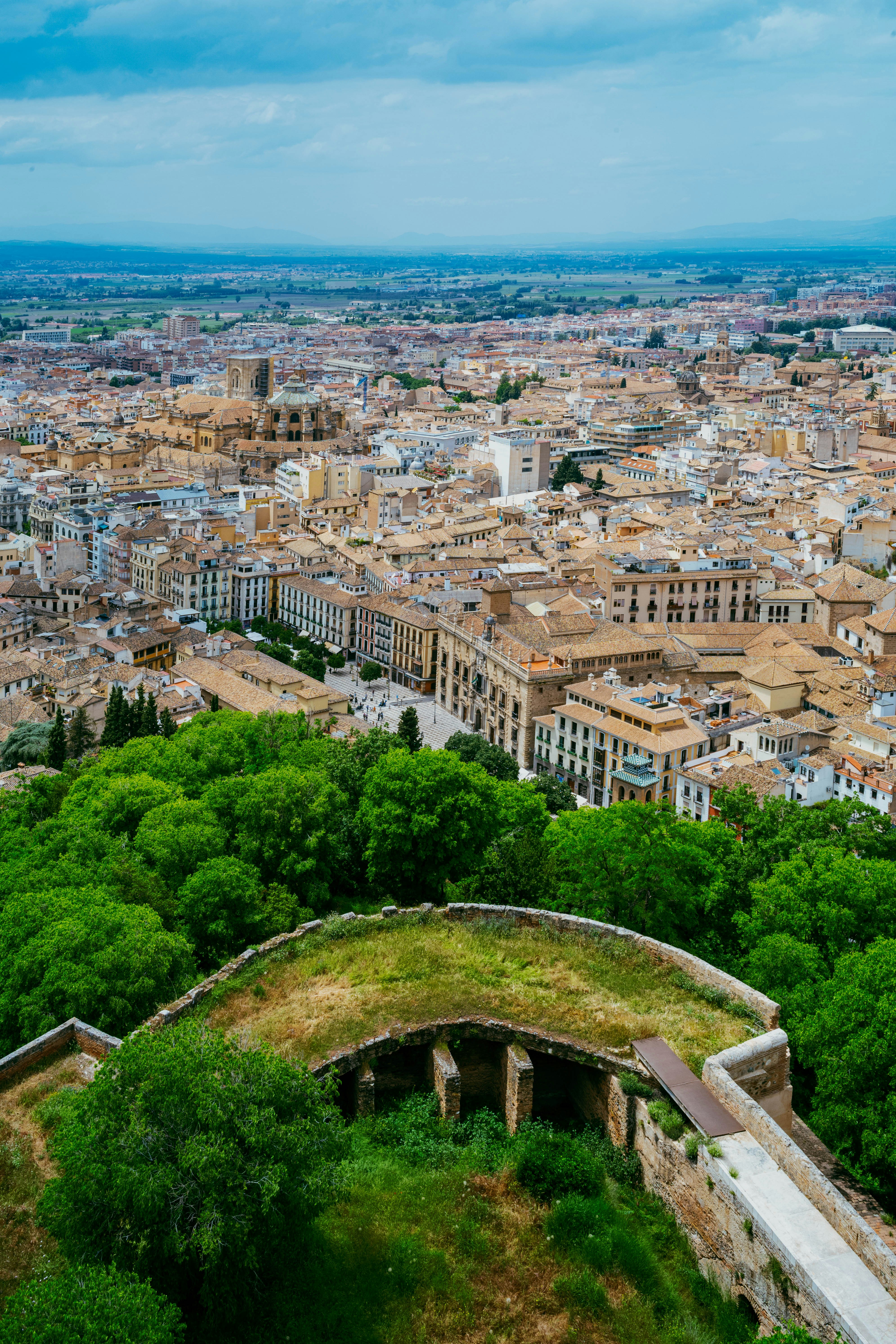 Overlook of a sunlit old town from a fortress terrace with verdant foreground