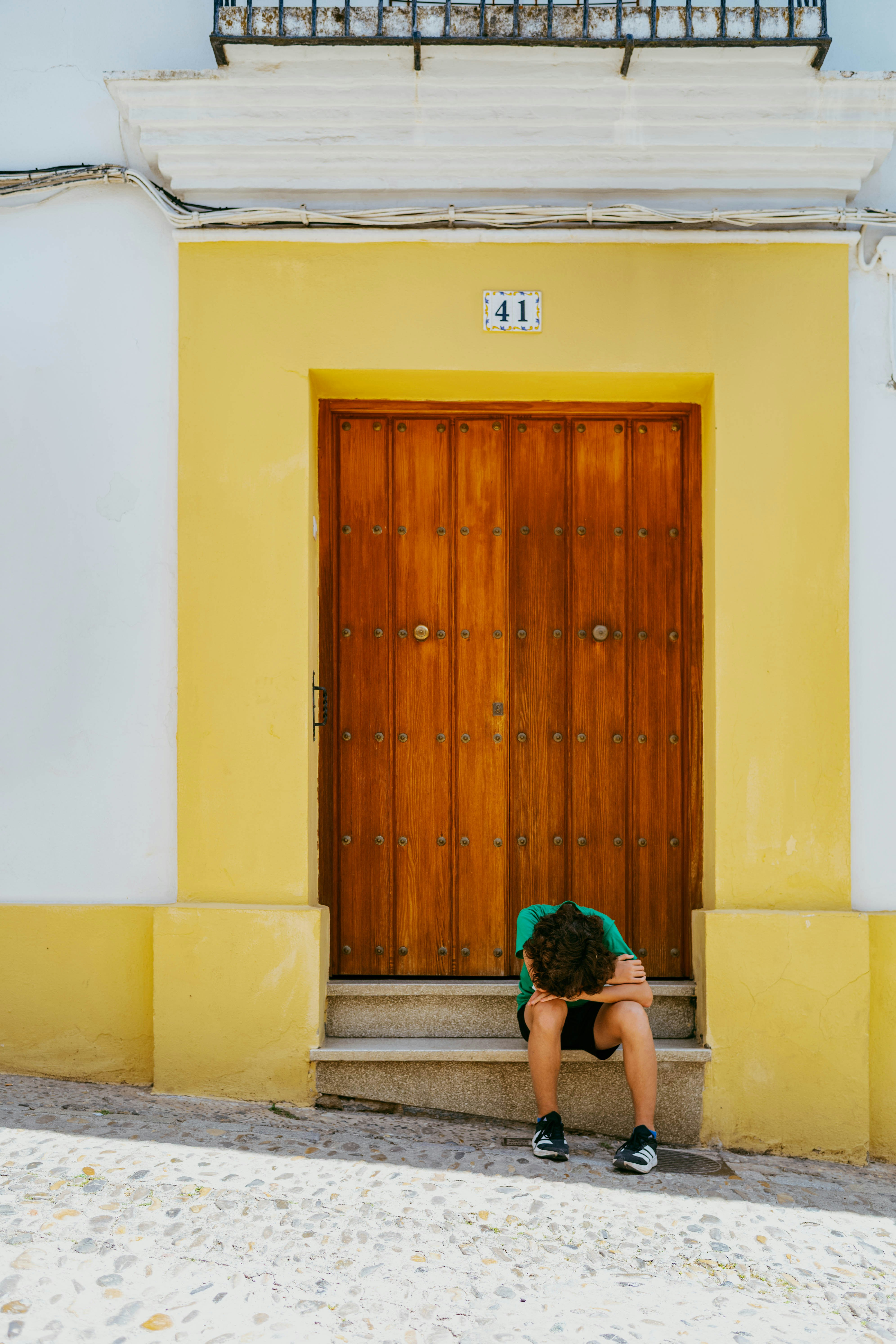 Yellow Facade and Burdened Step: A Quiet Moment Before Departure