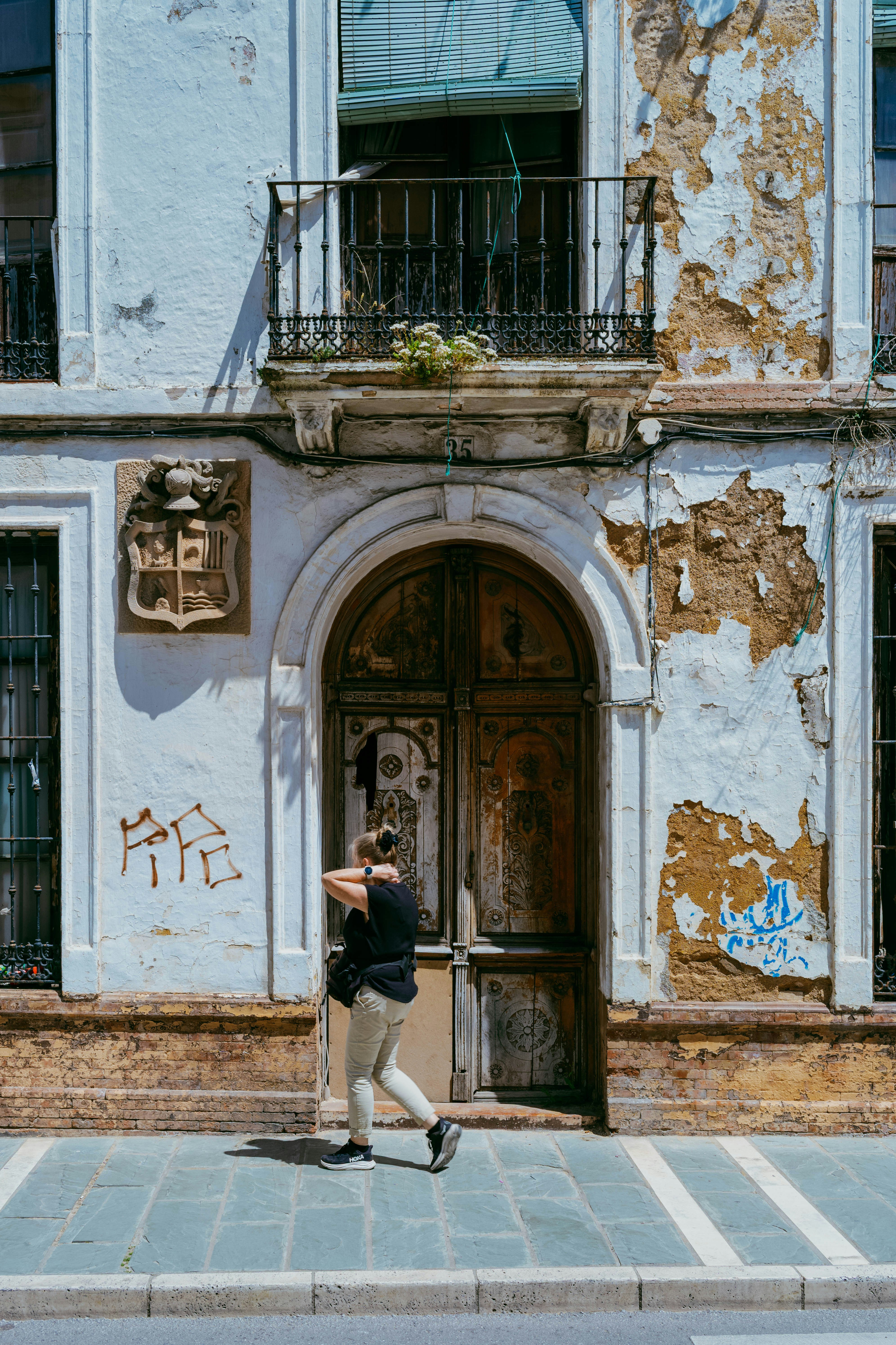 Worn Facade, Quiet Walk: A Moment at the Arched Doorway