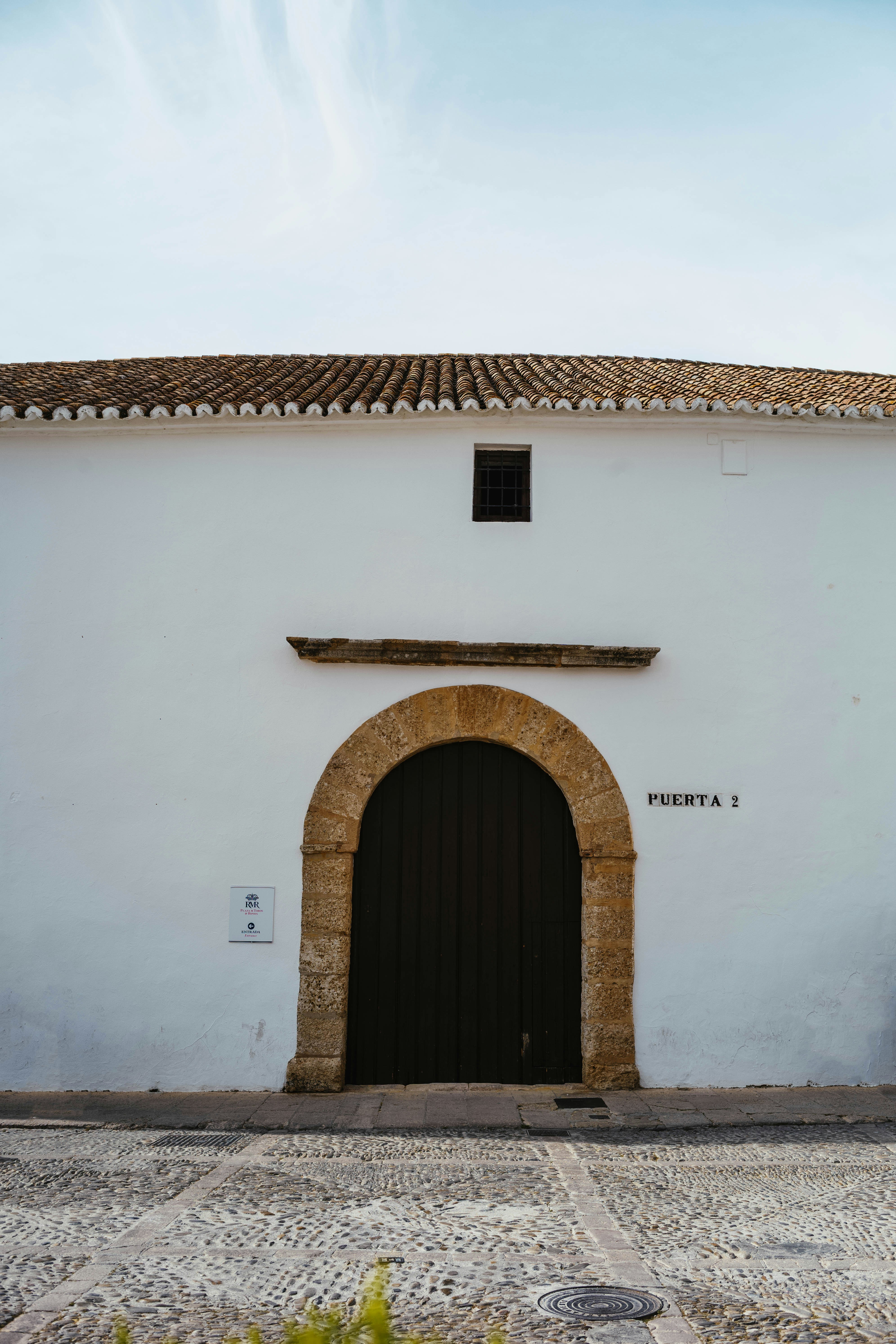 Arched Doorway in a Quiet White Facade