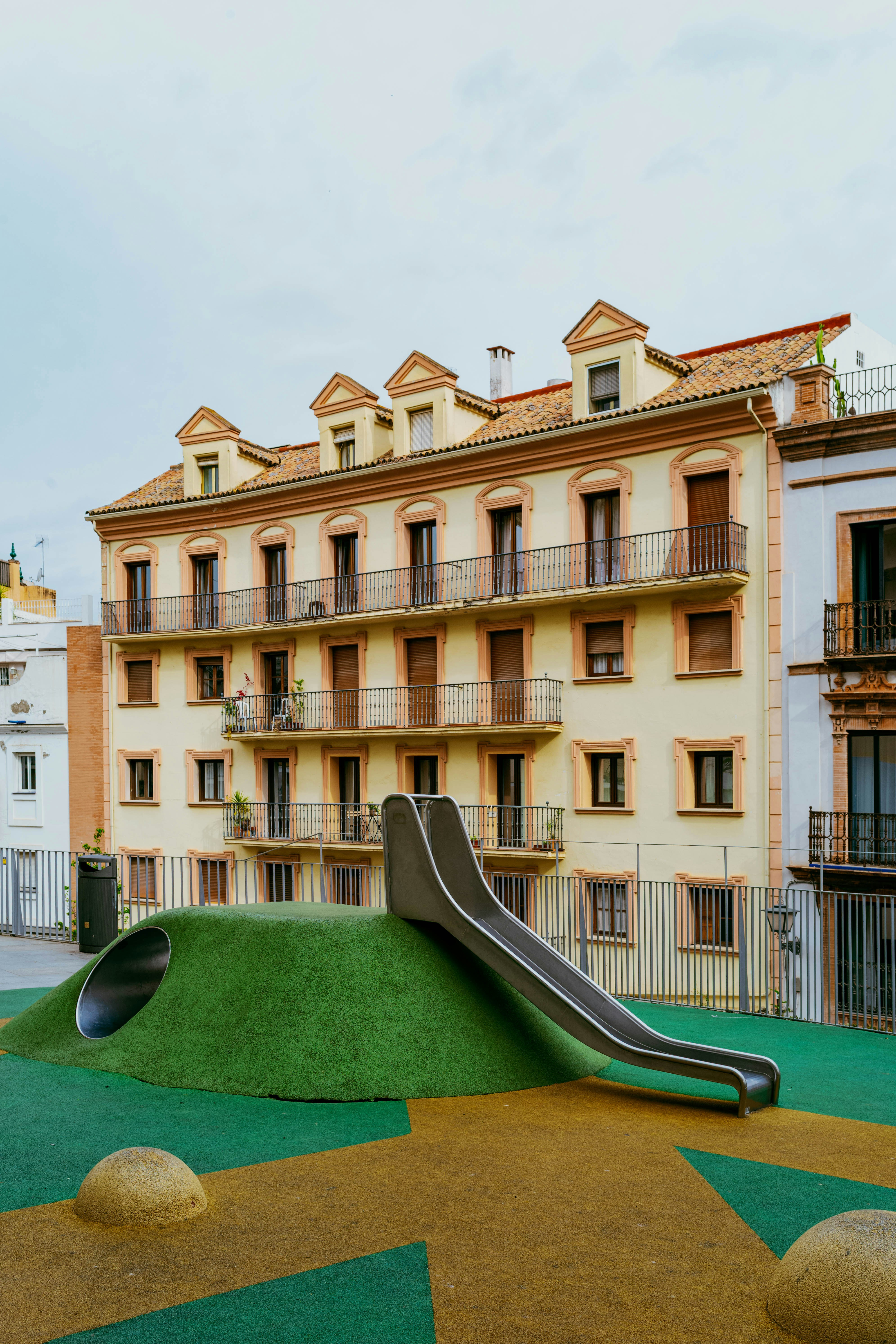 Playground Sunrise: A City-Hued Slide Edges a Gentle Giant of Color