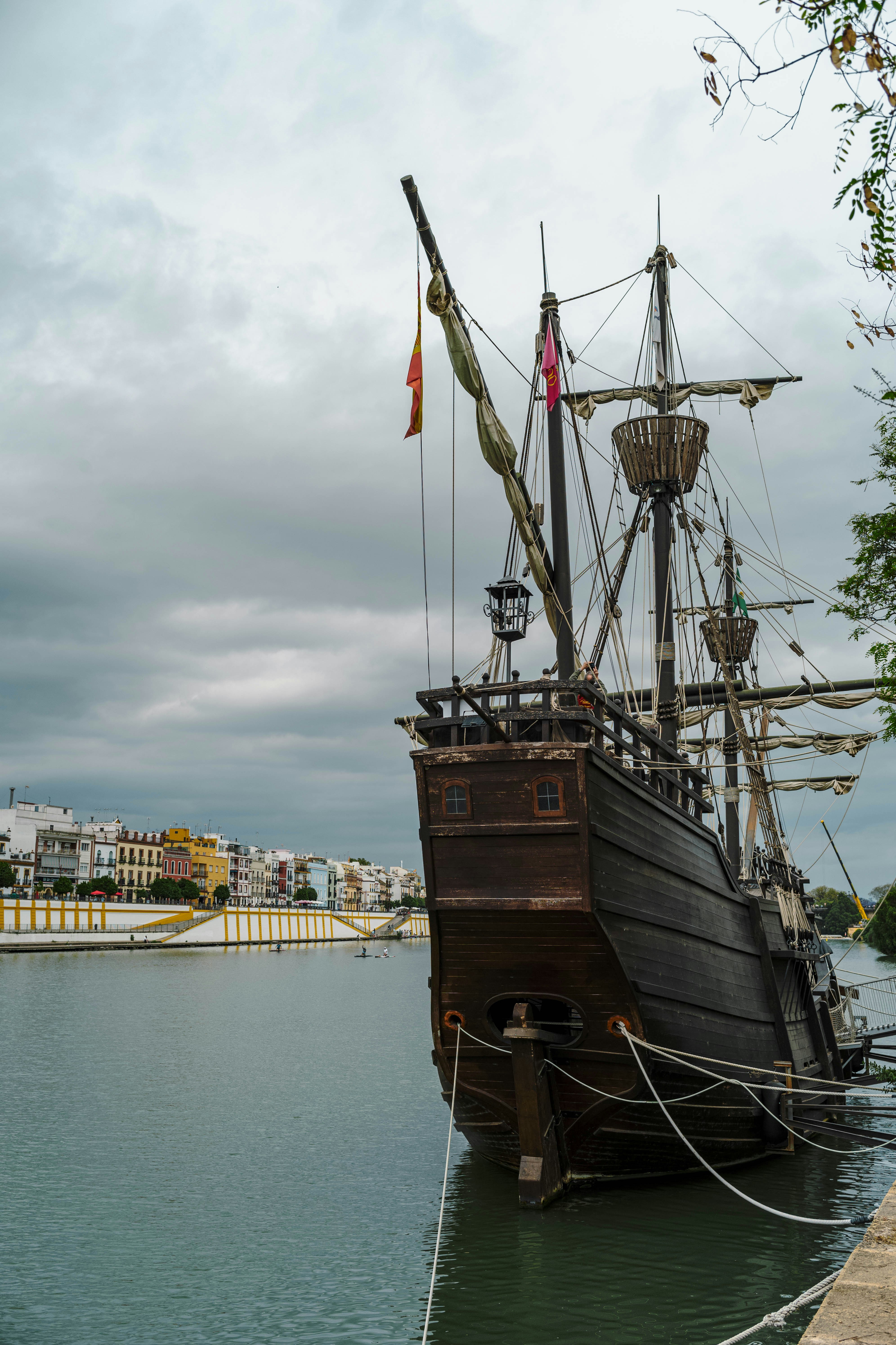 Tall Ship at Docks: A Weathered Vessel Anchored by a Quiet Waterfront