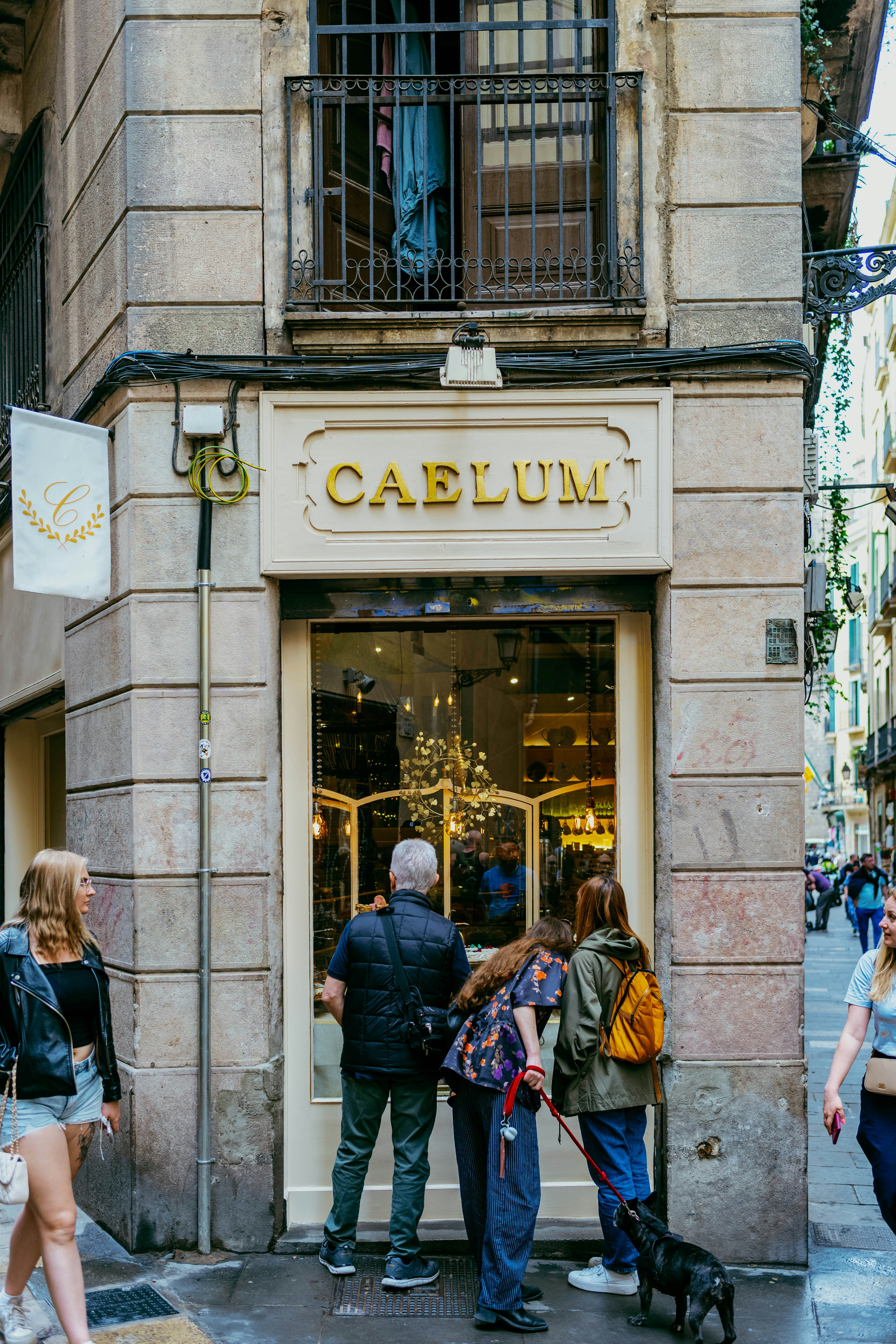 Caelum Shopfront: People Gather at a Boutique on a Narrow European Street