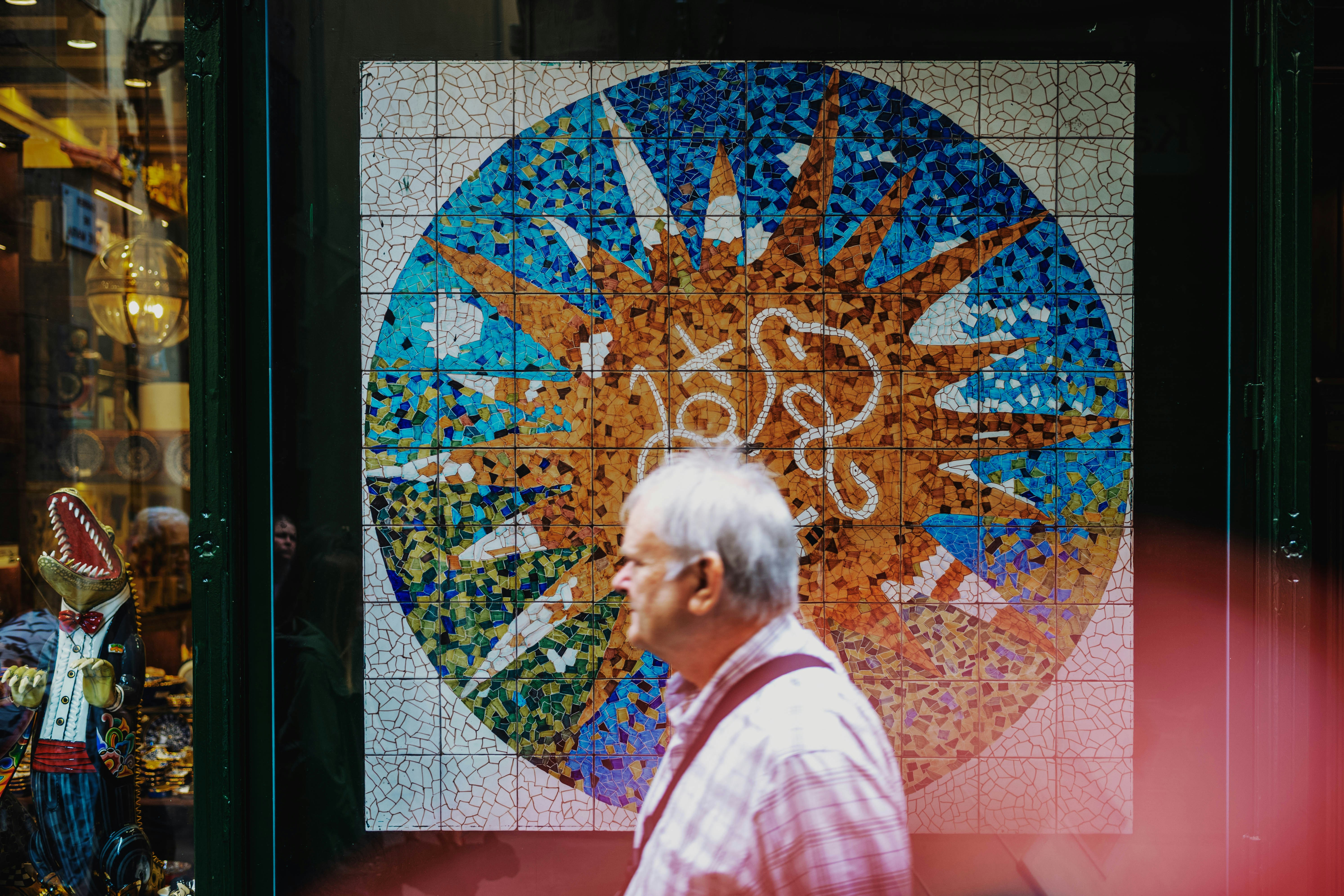 Circular Mosaic Spotlight: Elderly Gentleman in Front of a Sunburst Artwork