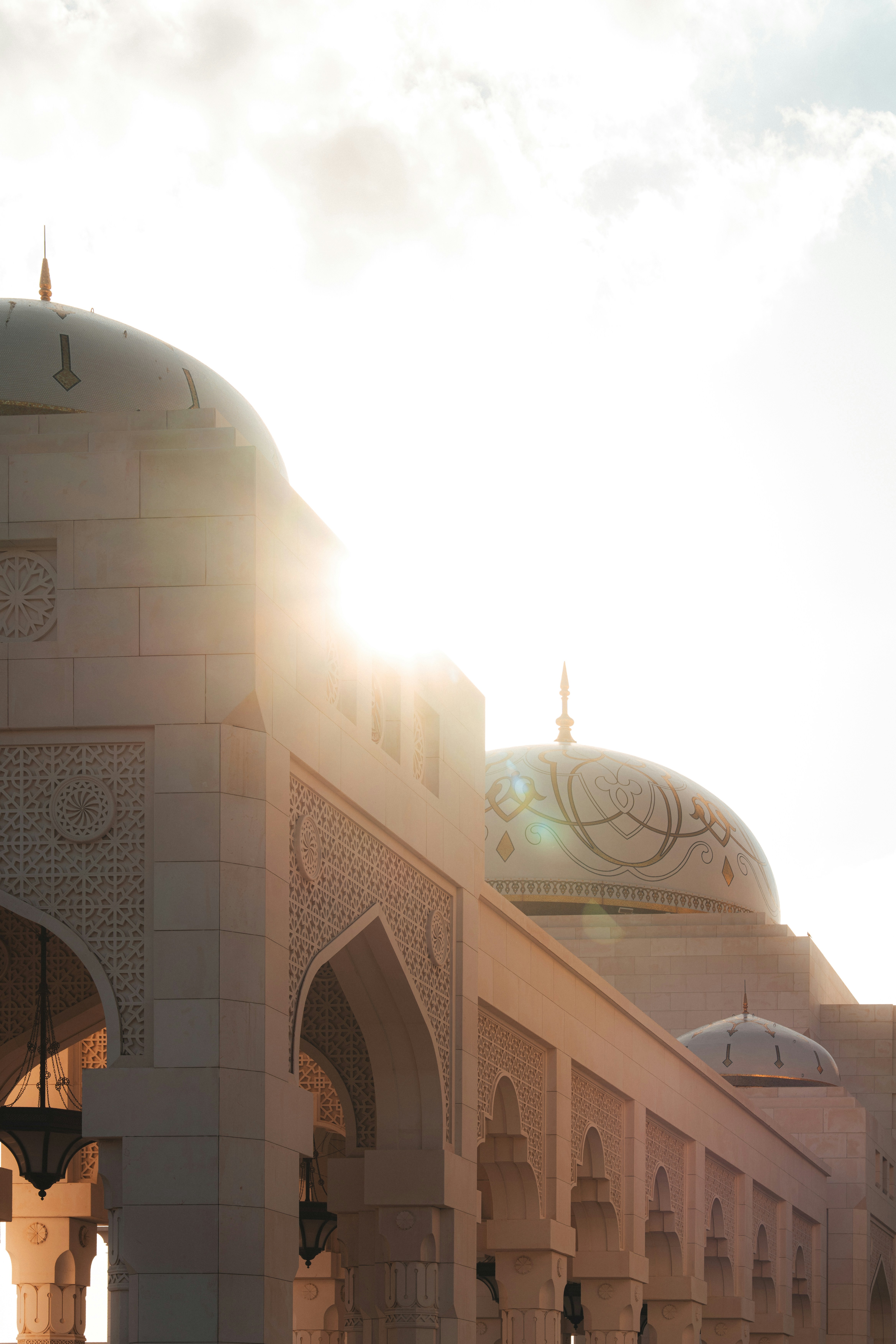 Sunlit arches of an ornate mosque fade into gold