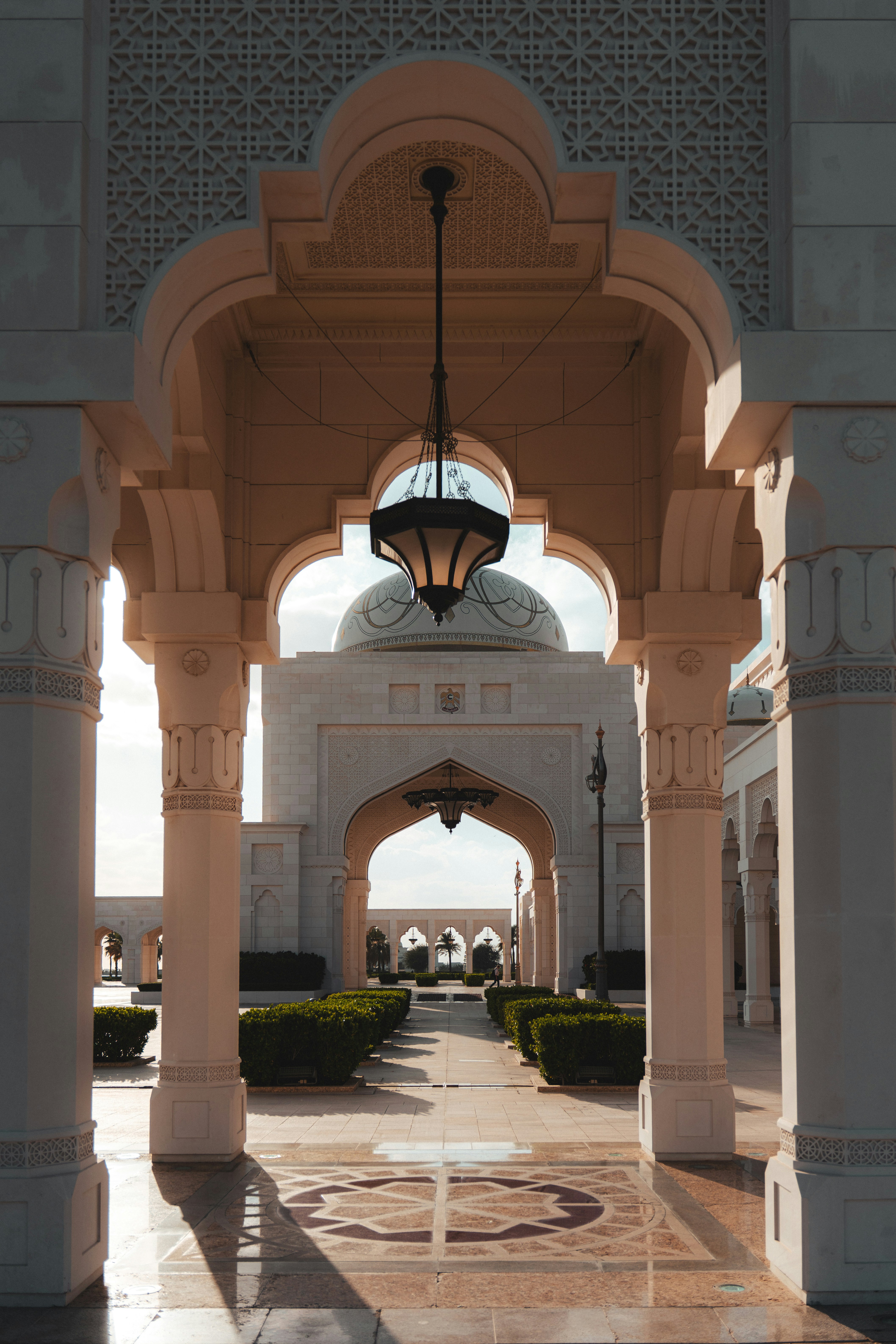 Ornate archway with a lantern leading to a garden path.