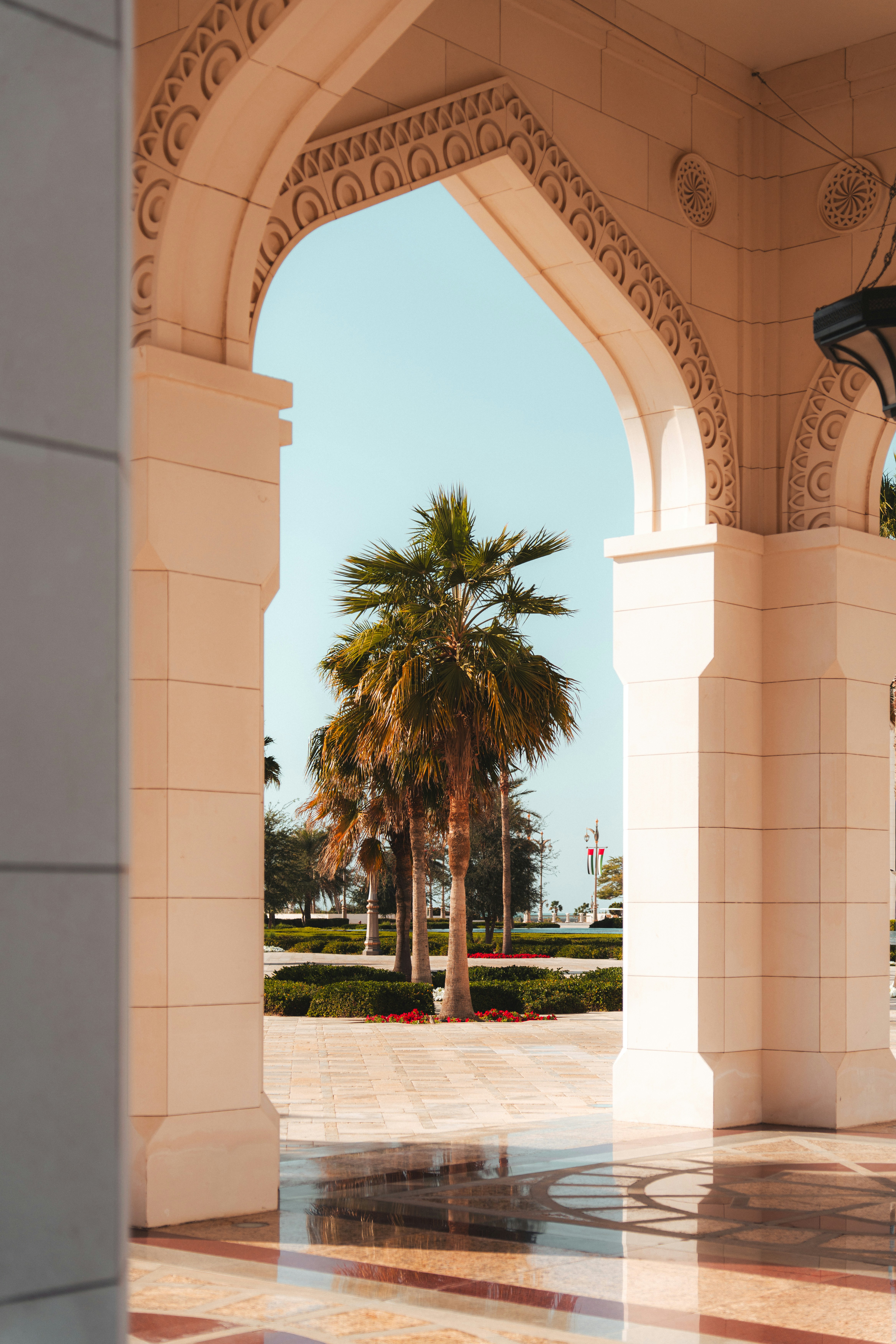 Palm-fringed archway frames a sunlit courtyard