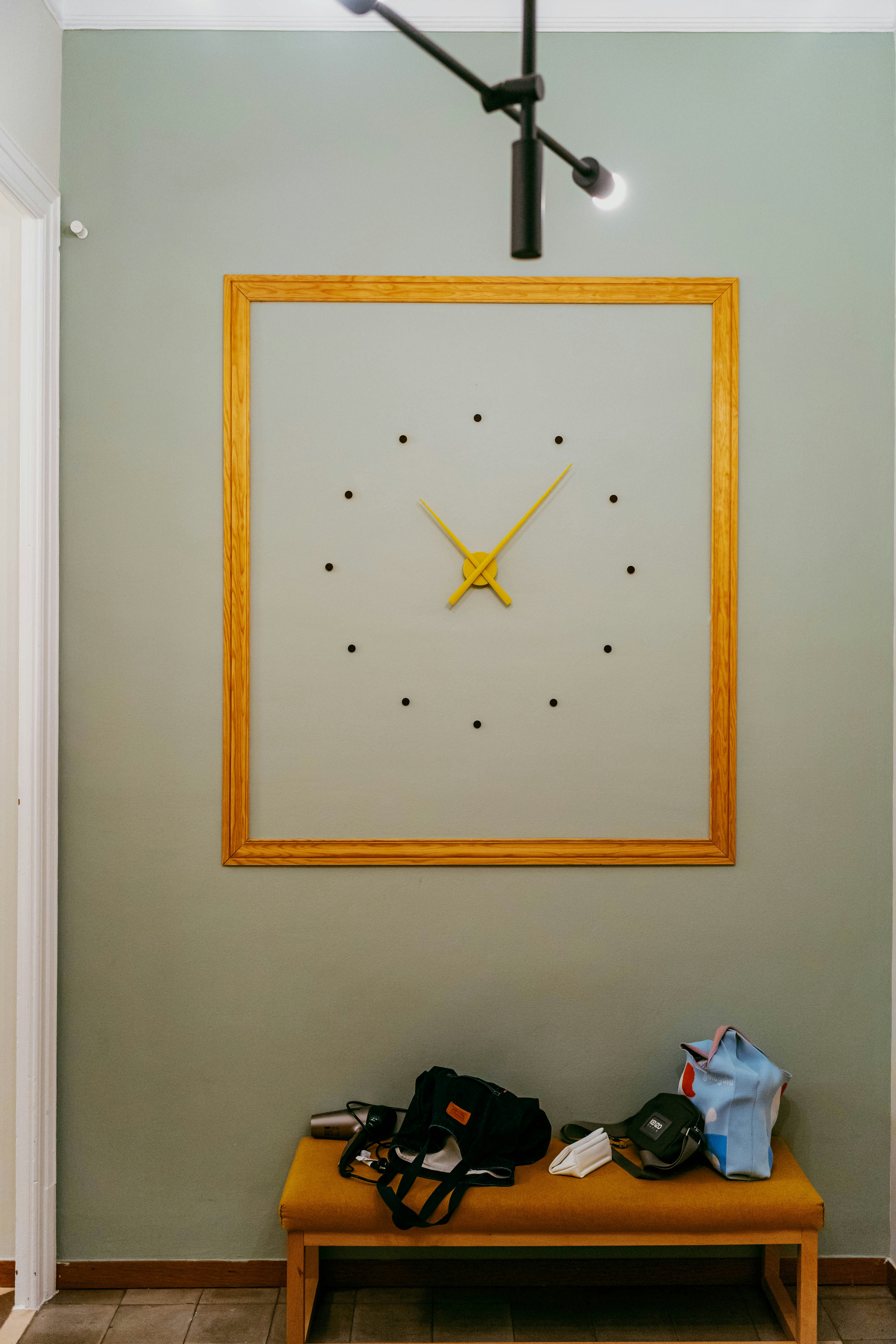 Golden Hands, Quiet Gallery: A Clock Adorns the Green Wall