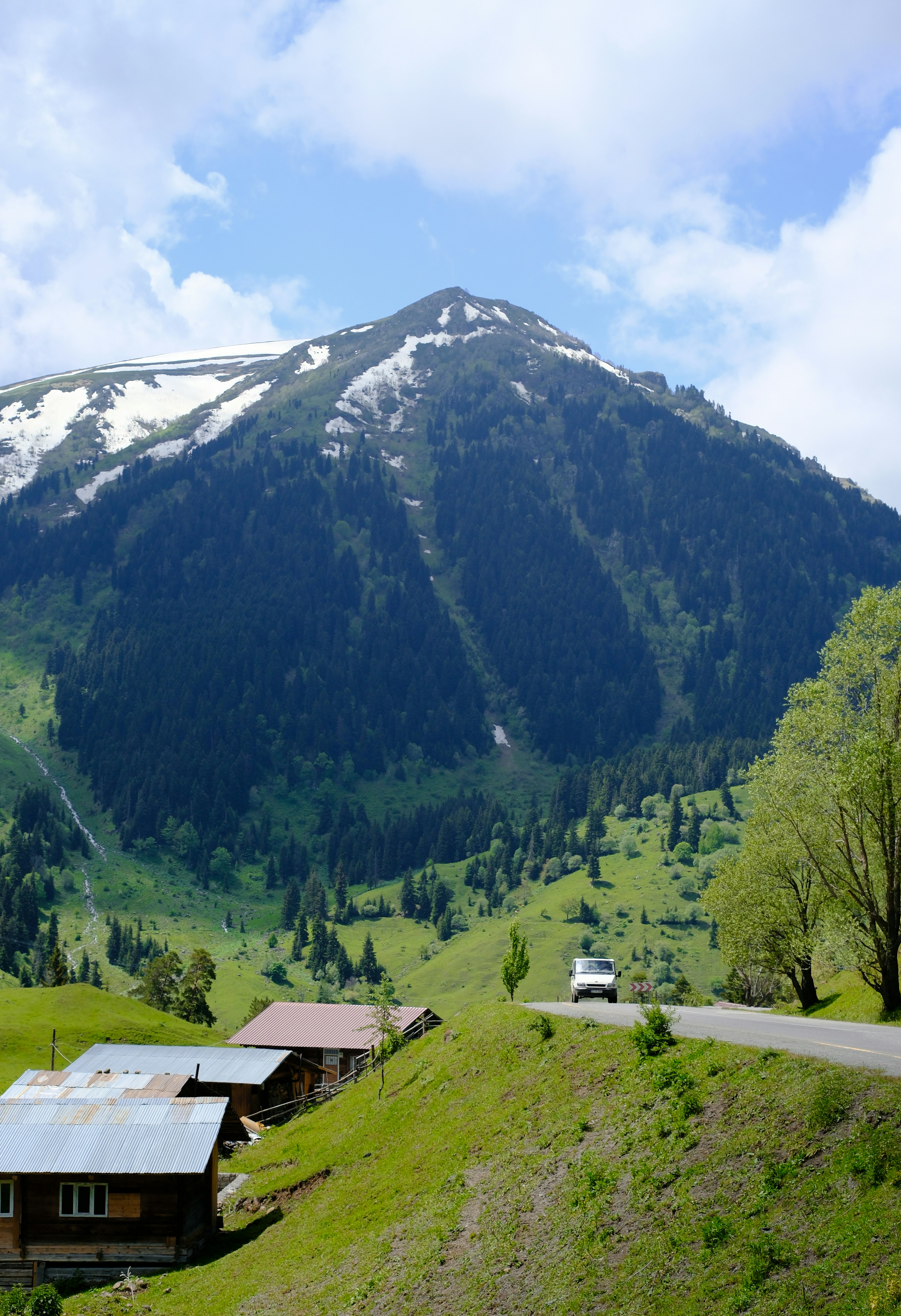 Mountain Trail and Cabin Village Beneath Snow-Cleeted Peak