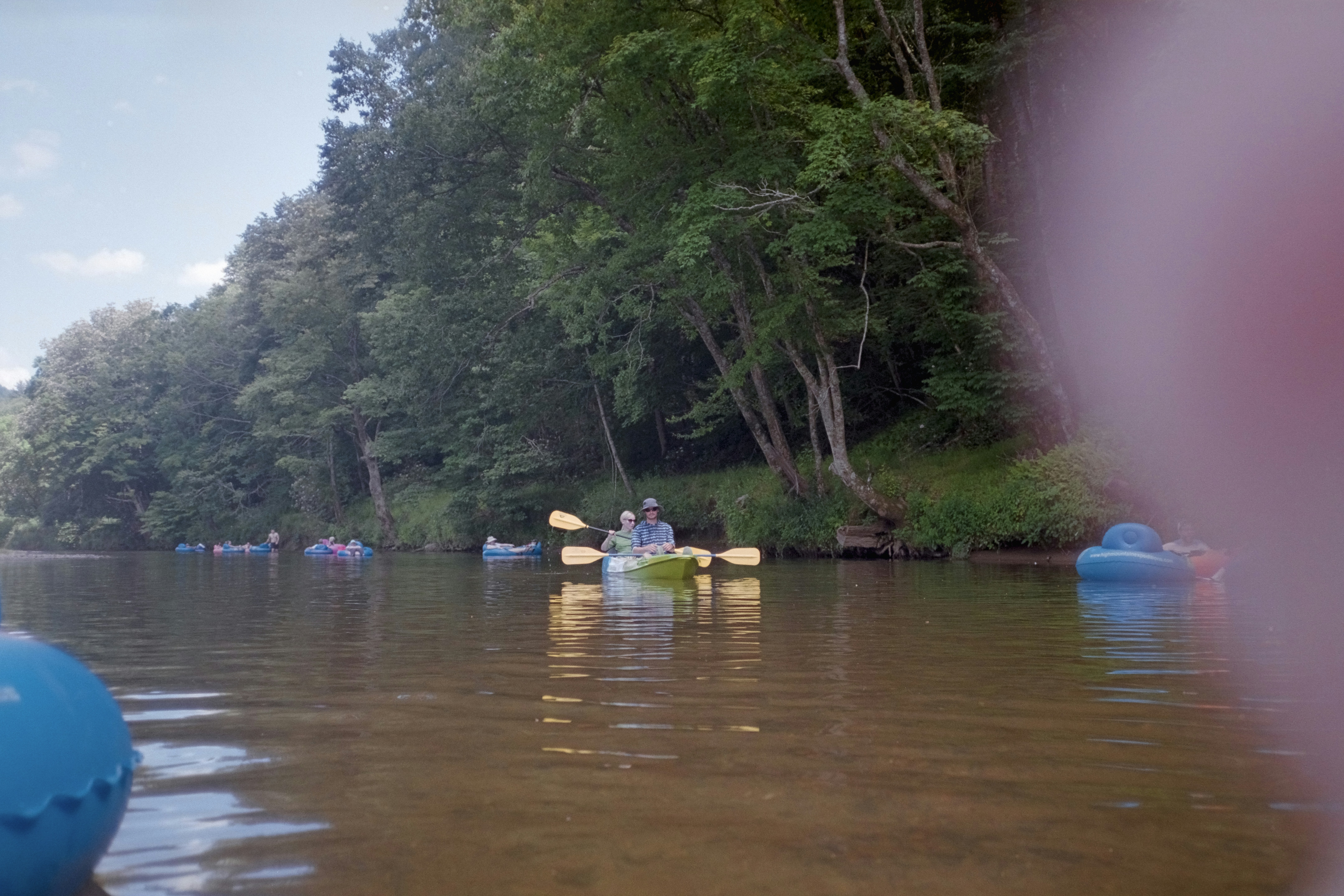 Centered paddler in a tranquil river awaits the bend