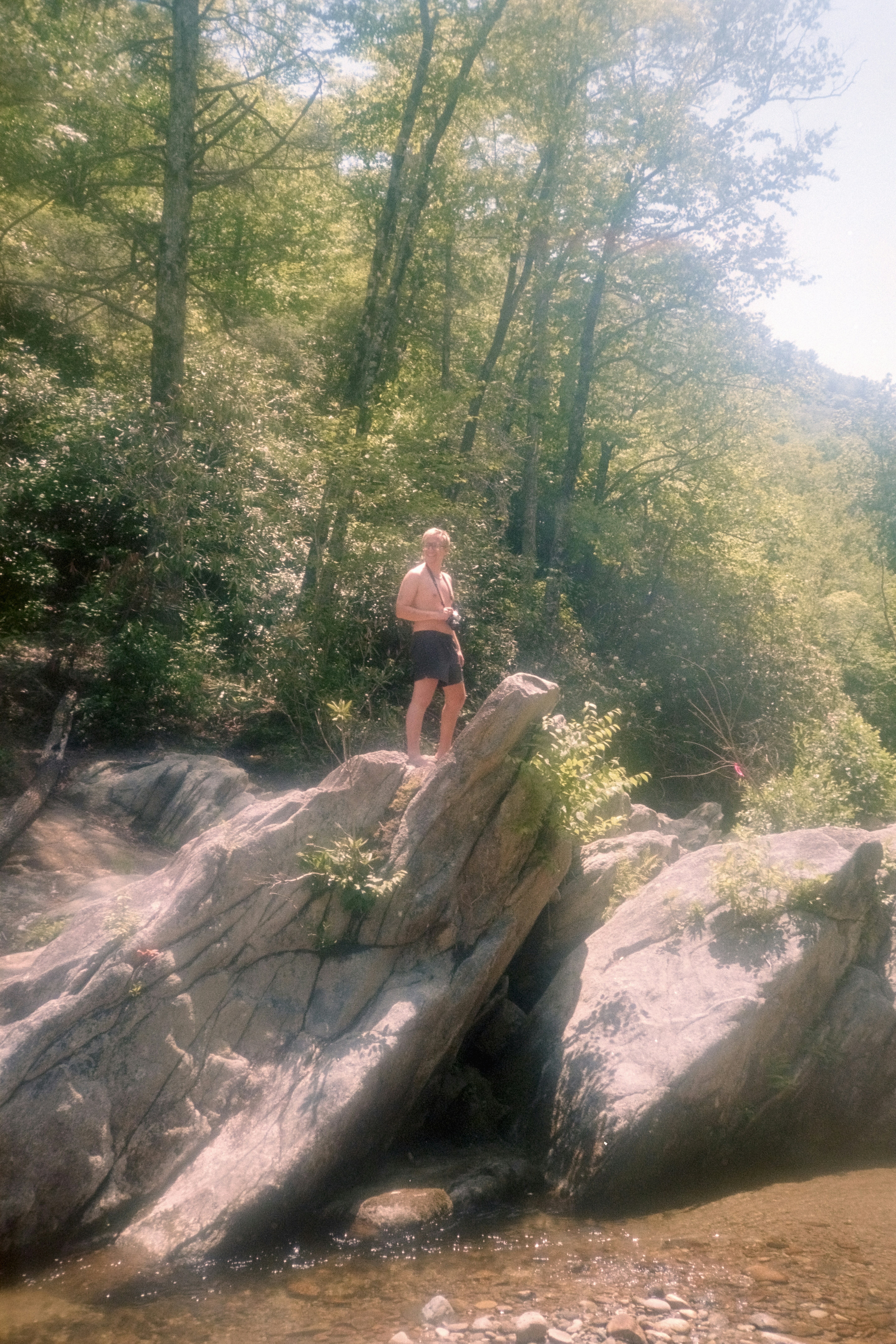 Cliffside silhouette: a lone hiker anchored on sunlit rock
