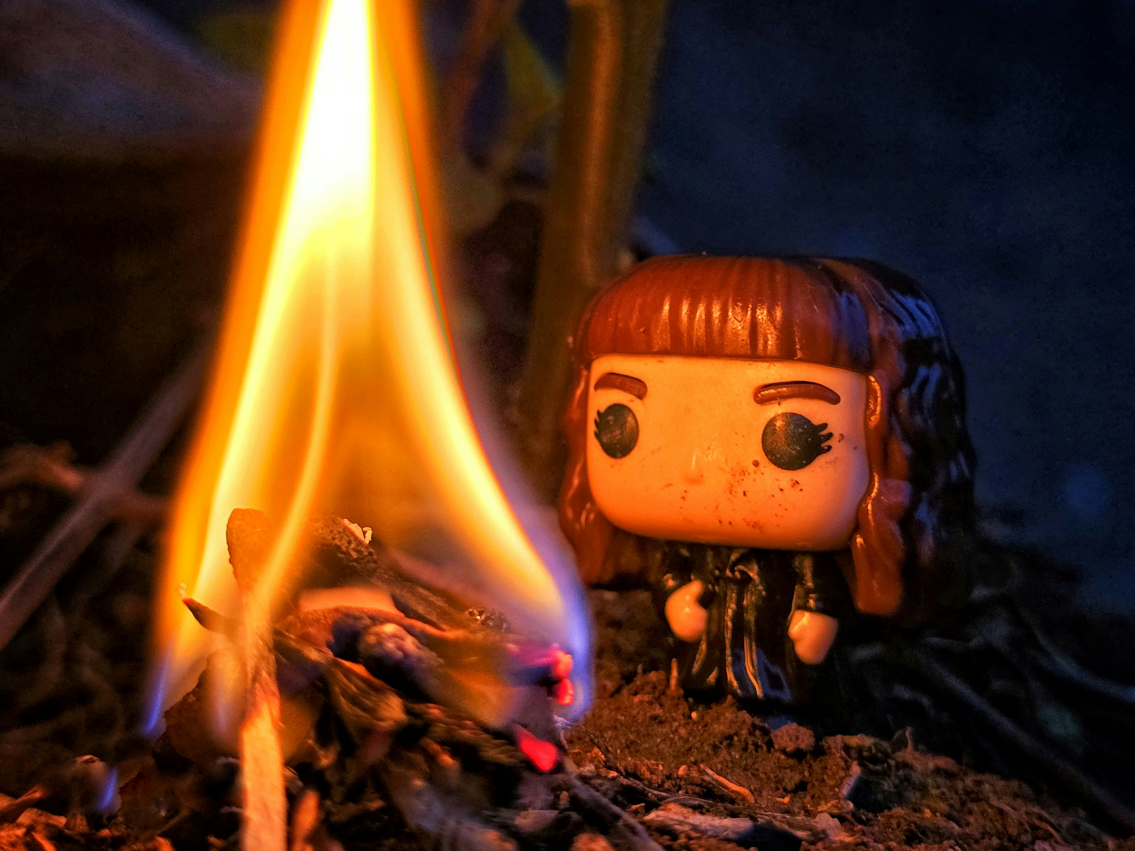 Miniature Witness by the Flame: A Funko Pop Beneath Campfire Glow
