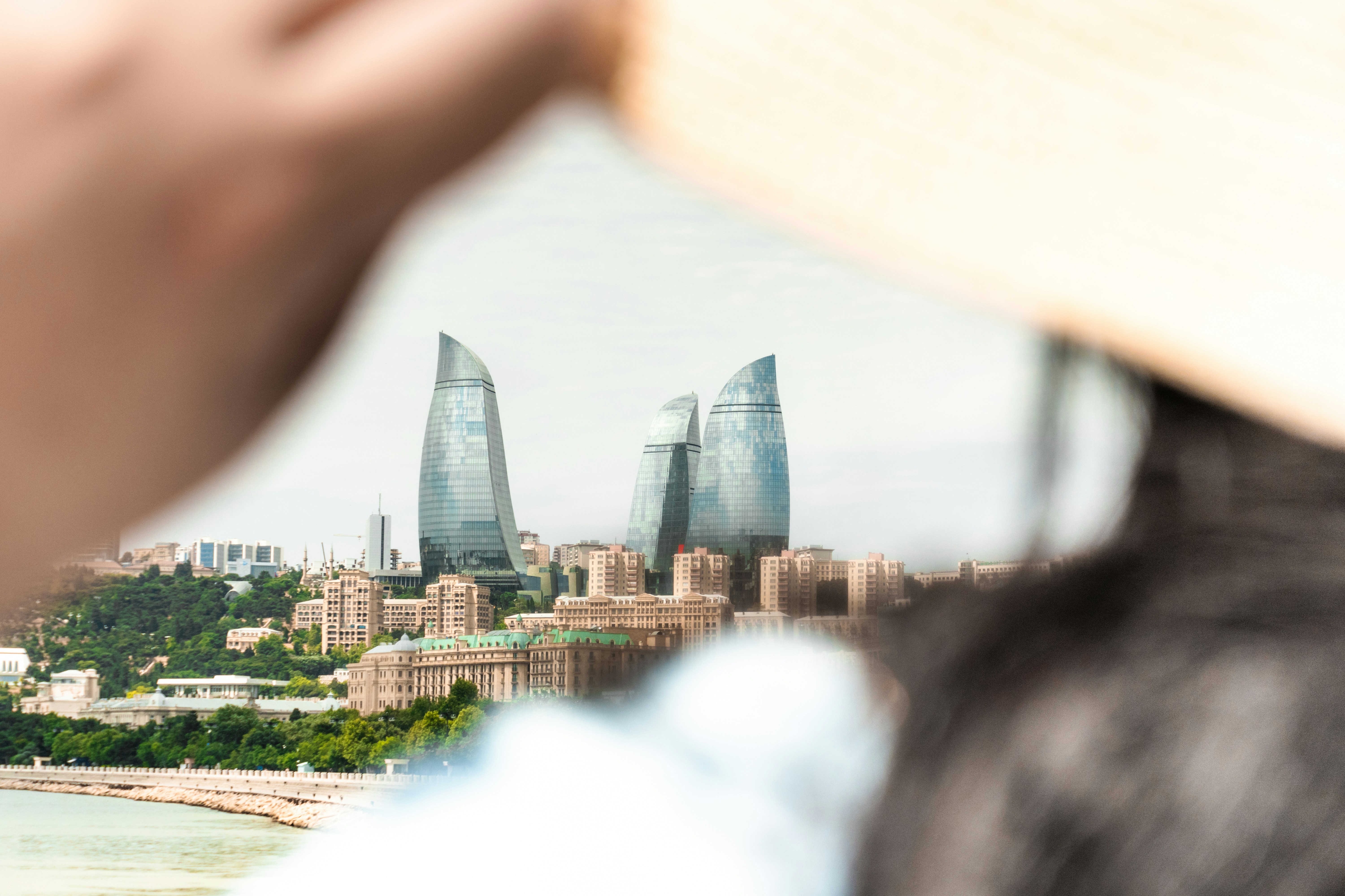 City Framed Between Blurred Shoulders: Towering Ends Emerging from a Palm-Soft Frame
