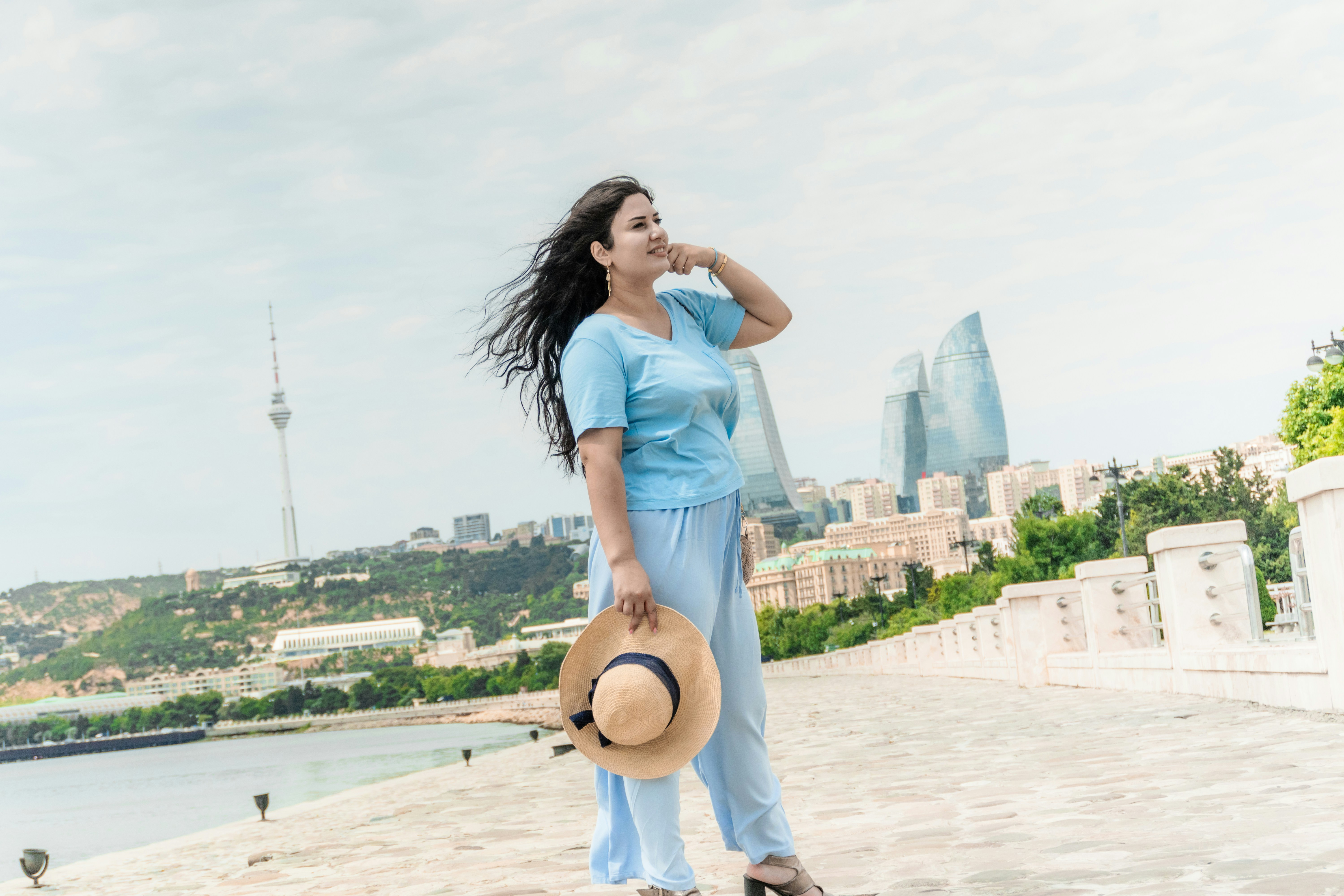 Coastal Pose: Blue Attire and City Echoes by the Waterfront