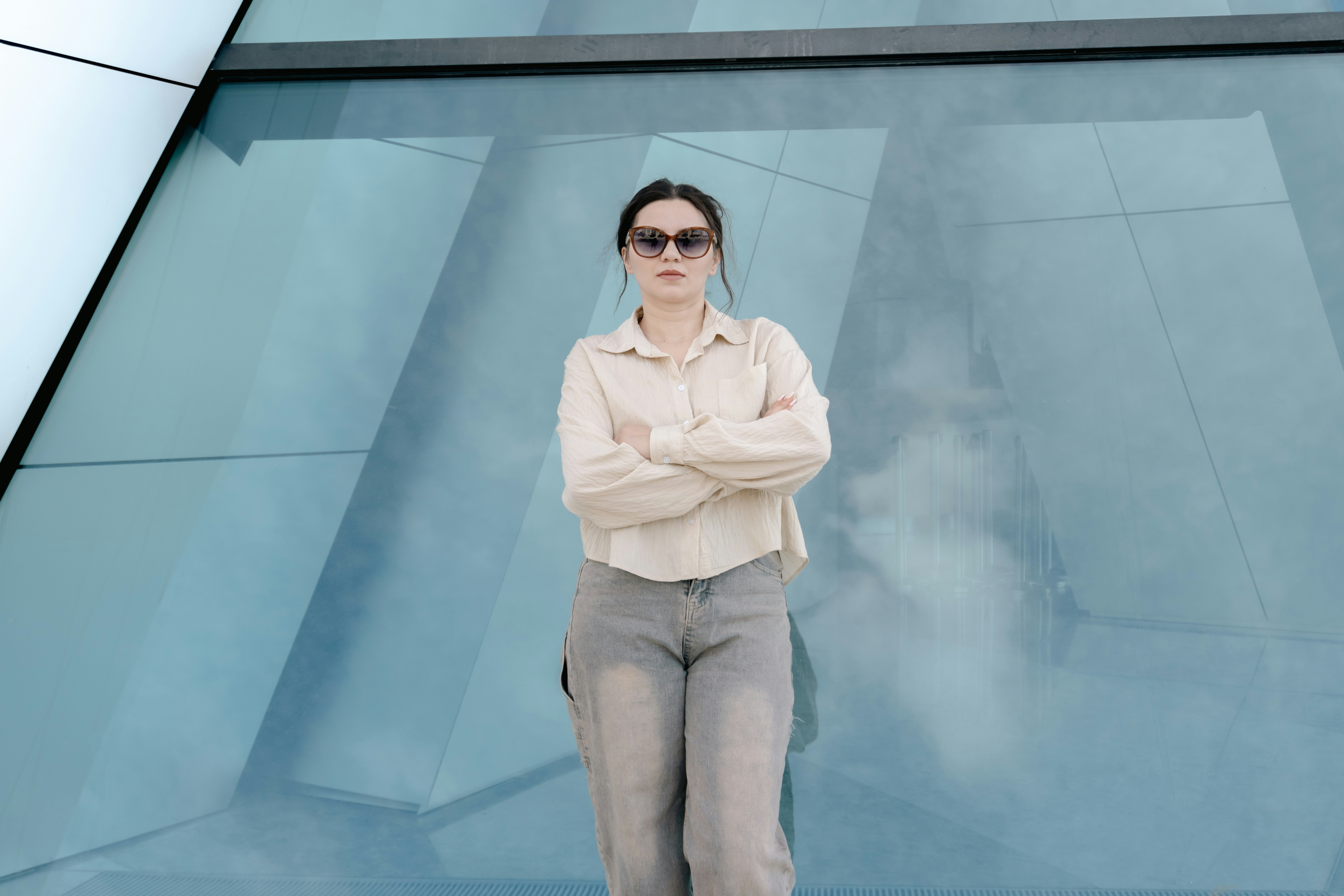 Portrait in Glass: Confident Stance Before a Geometric Facade