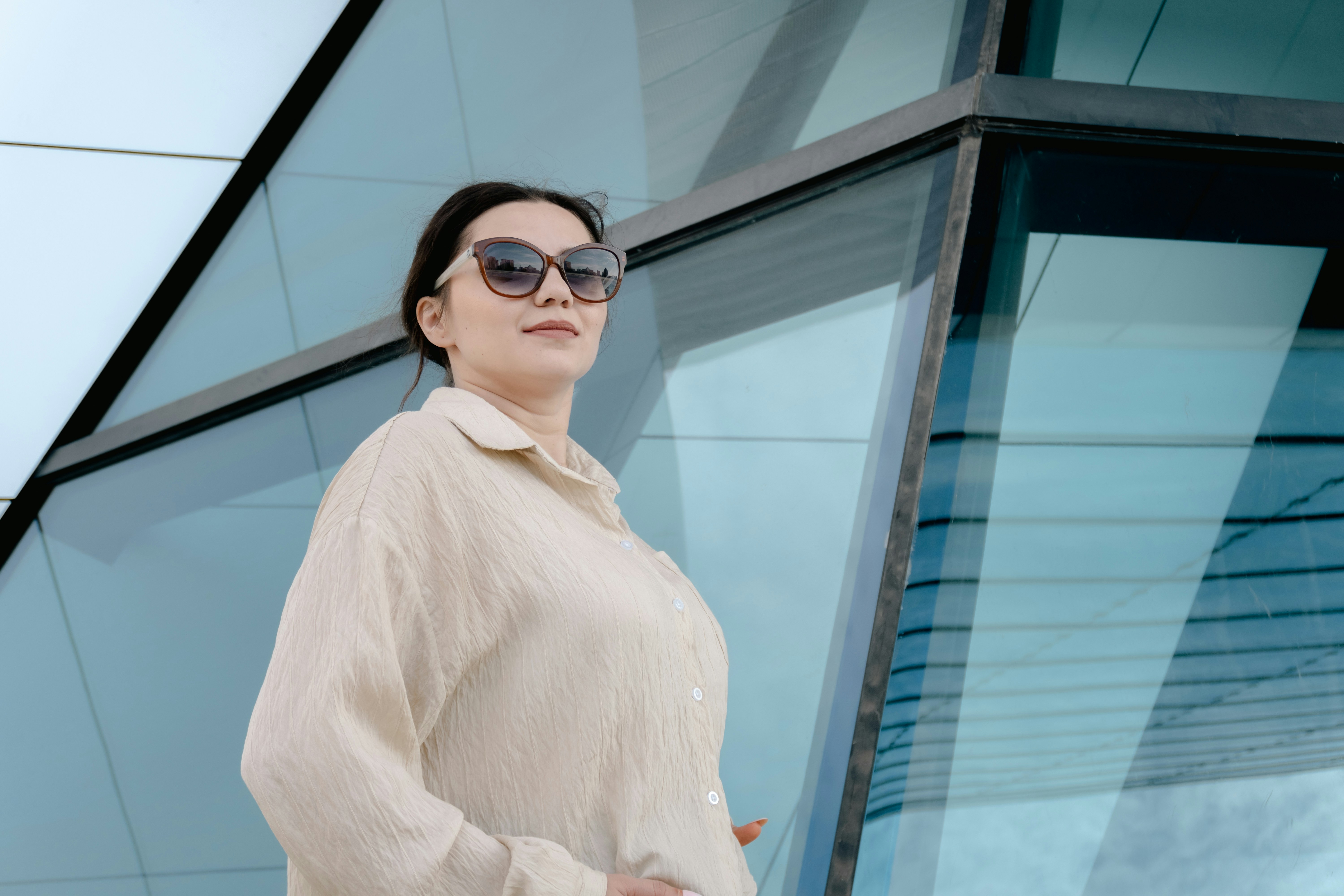 Chic Confidence: A Stylish Portrait Against Modern Glass Architecture