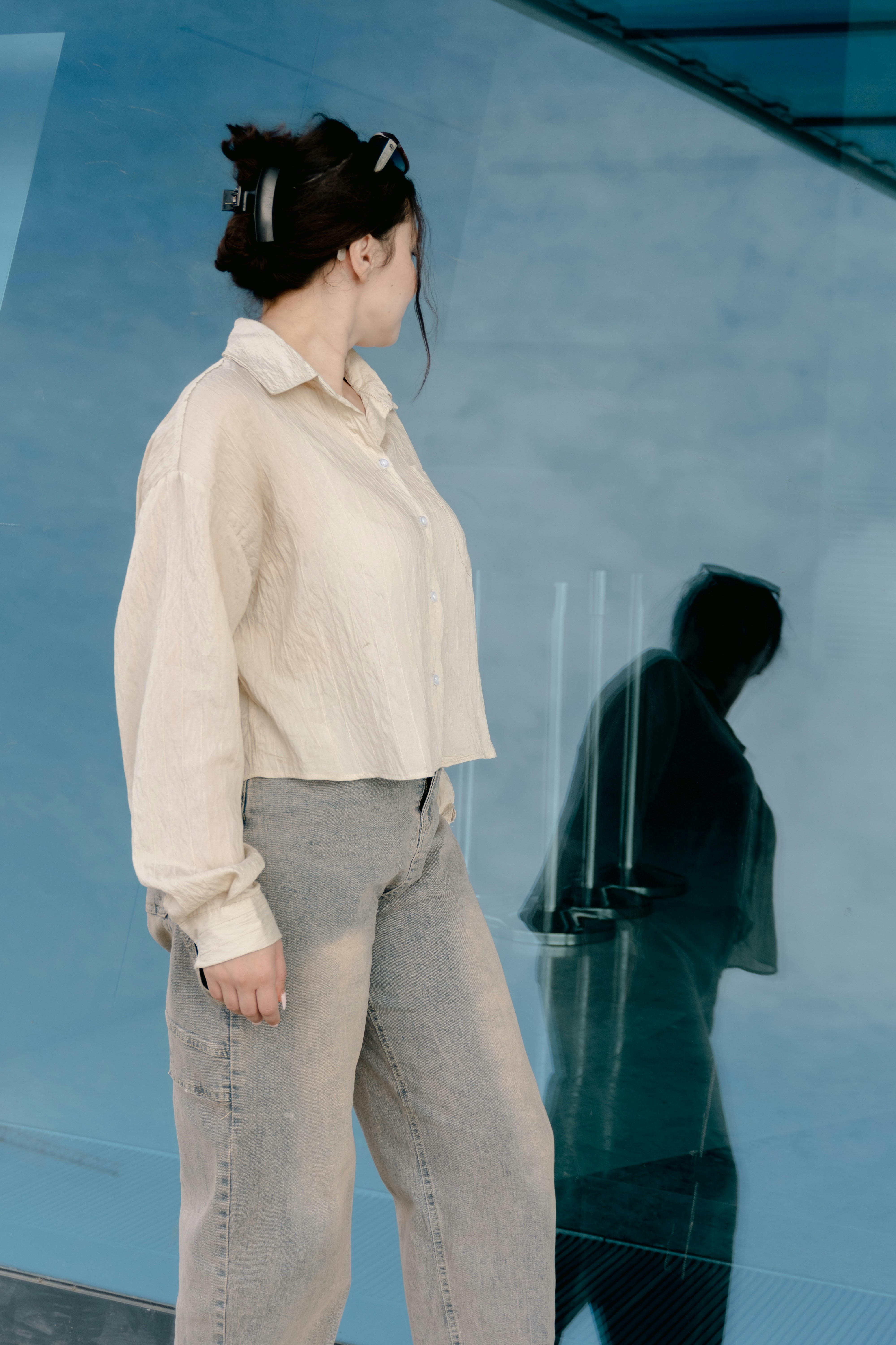 Quiet Confidence: A Woman in Neutral Tones by a Glass Facade