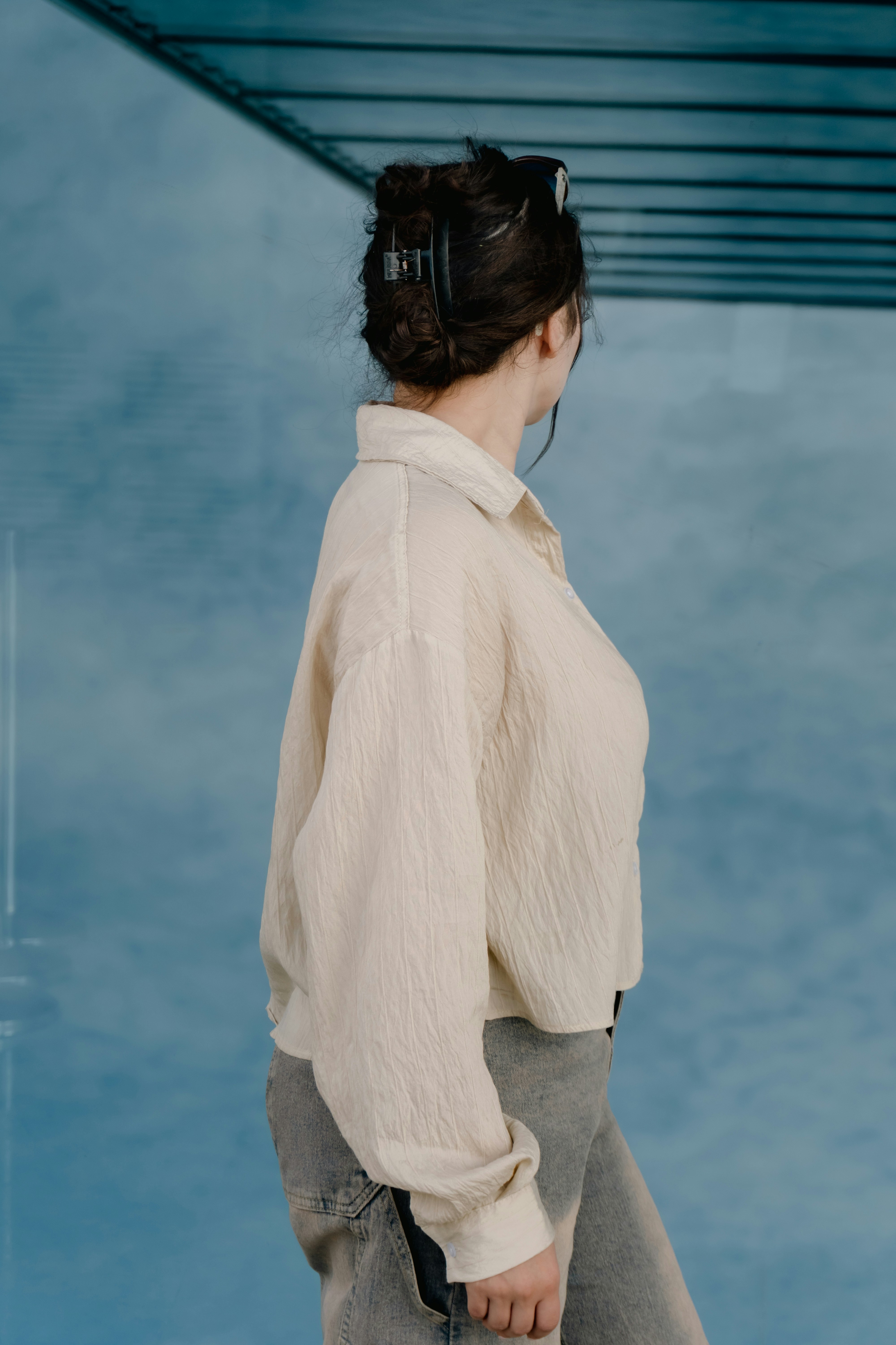 Profile in Soft Light: A Quiet Pause by the Blue Wall