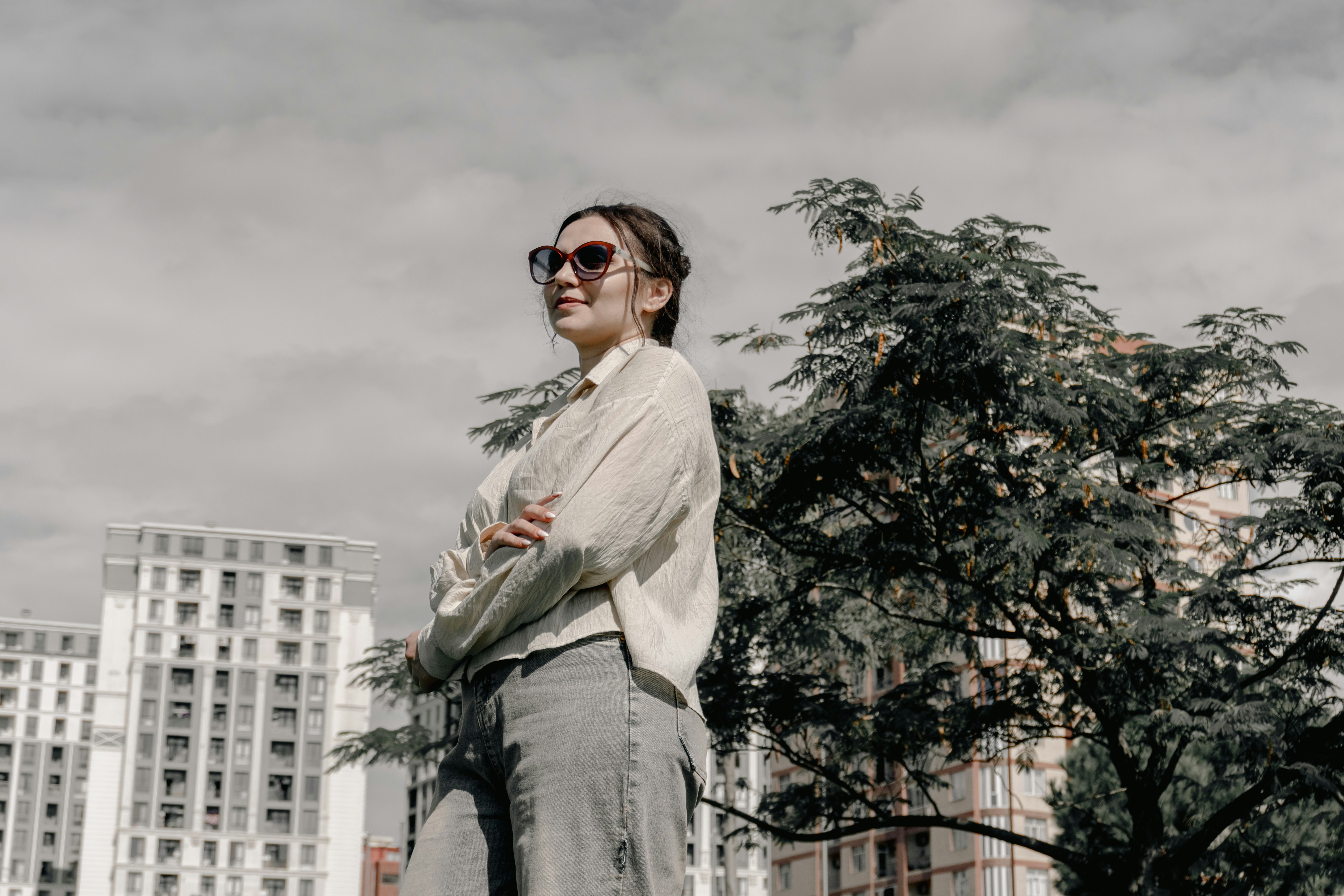 Urban Confidence: A Woman in Light Knit Overcoat Against the City’s Edge
