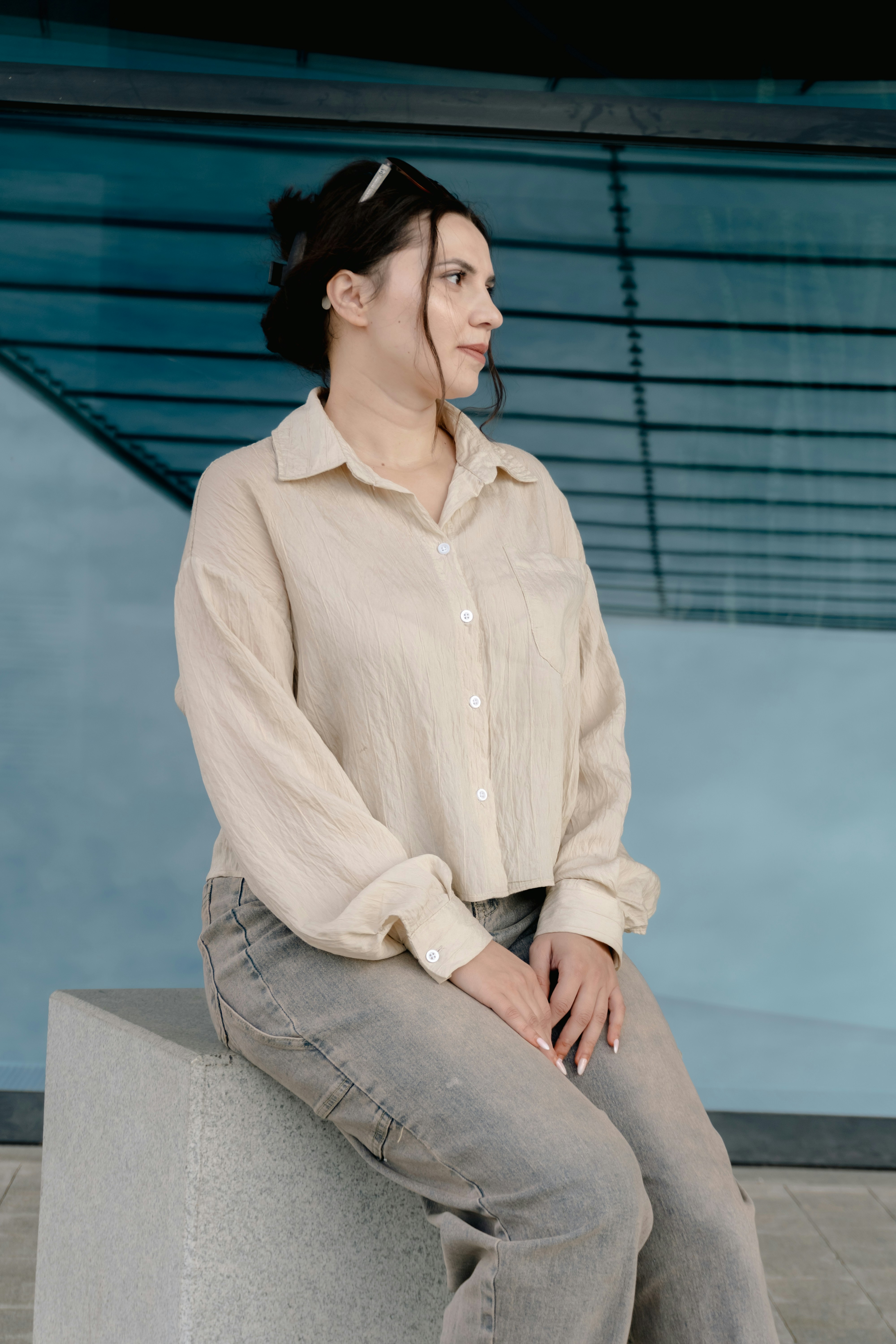 Quiet Confidence: A Woman in Neutral tones Beneath Blue Architecture
