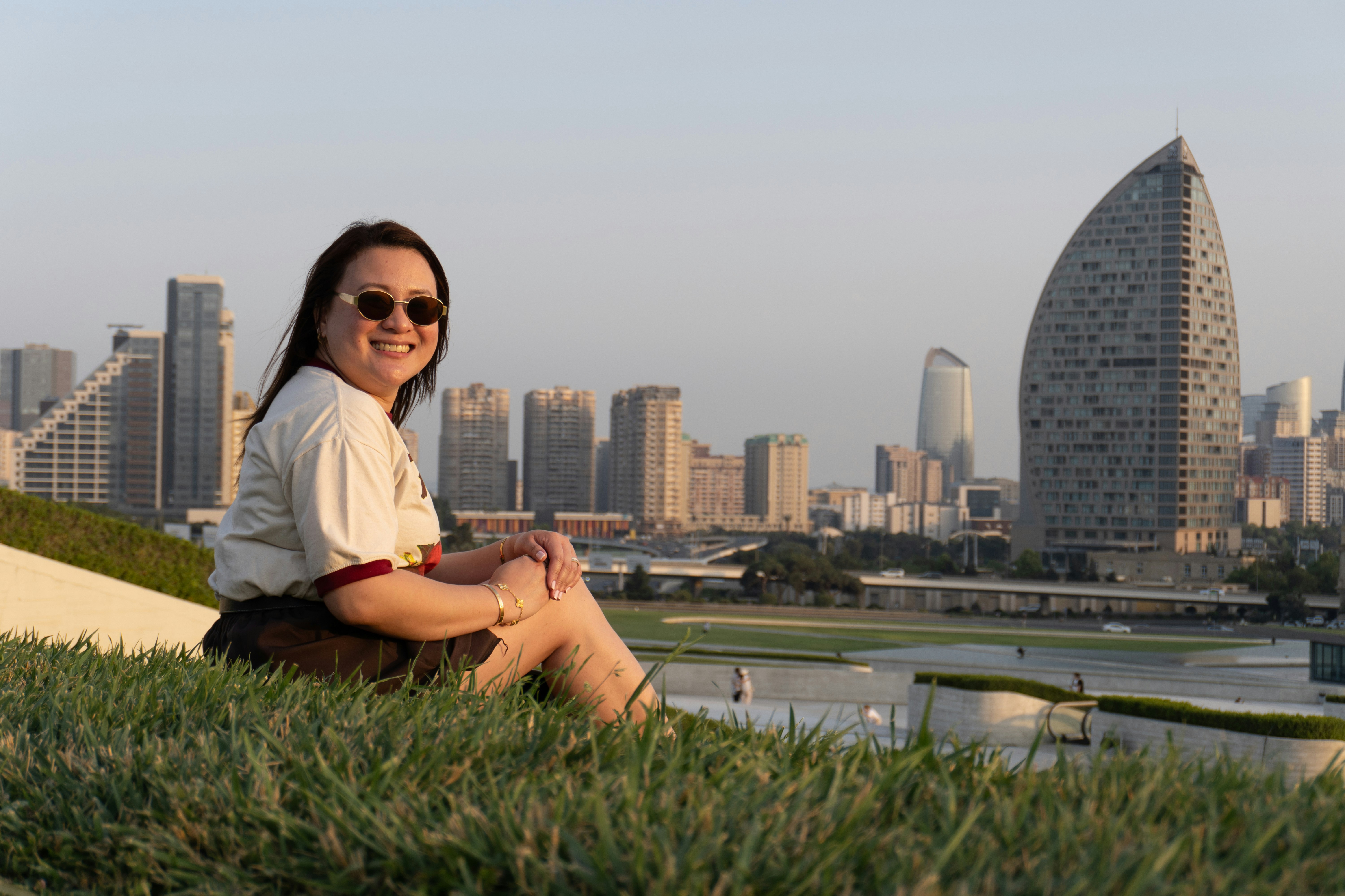 Sunset Cityscape Serenade: A Woman in a Quiet Riverside Vista