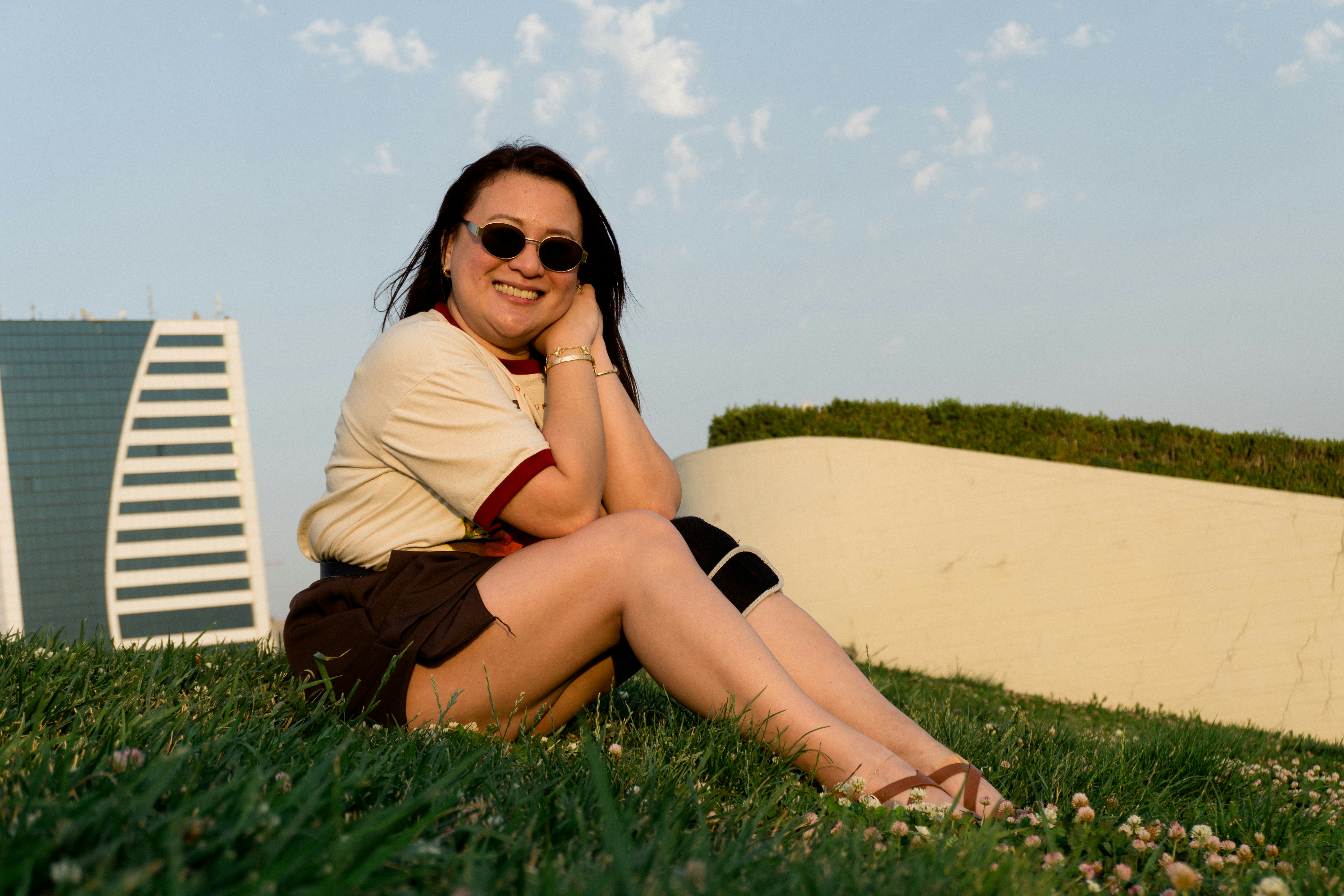 Relaxed portrait in sunlit park with modern backdrop