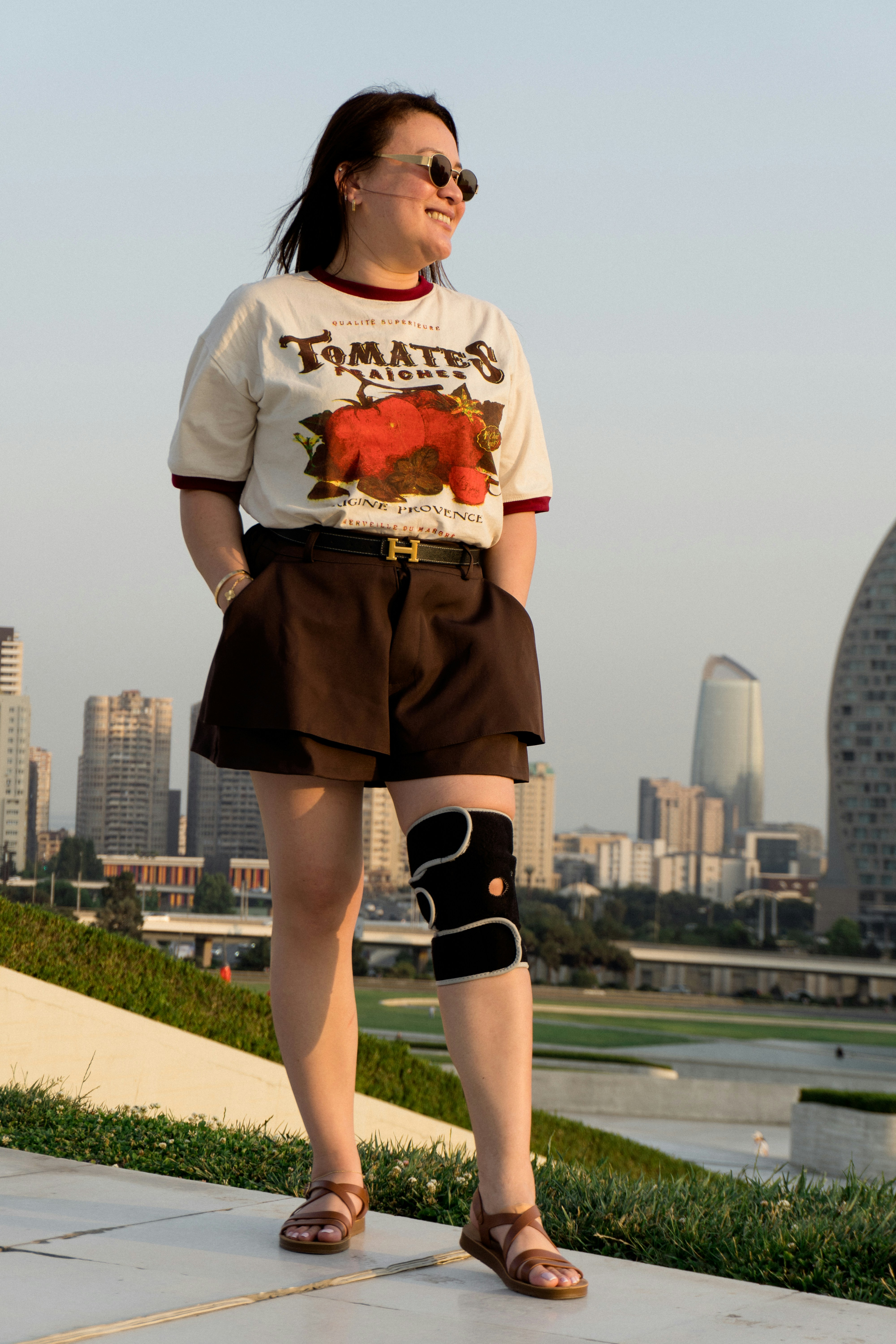Cityscape stroll: a sunlit portrait with a knee brace and vintage tee