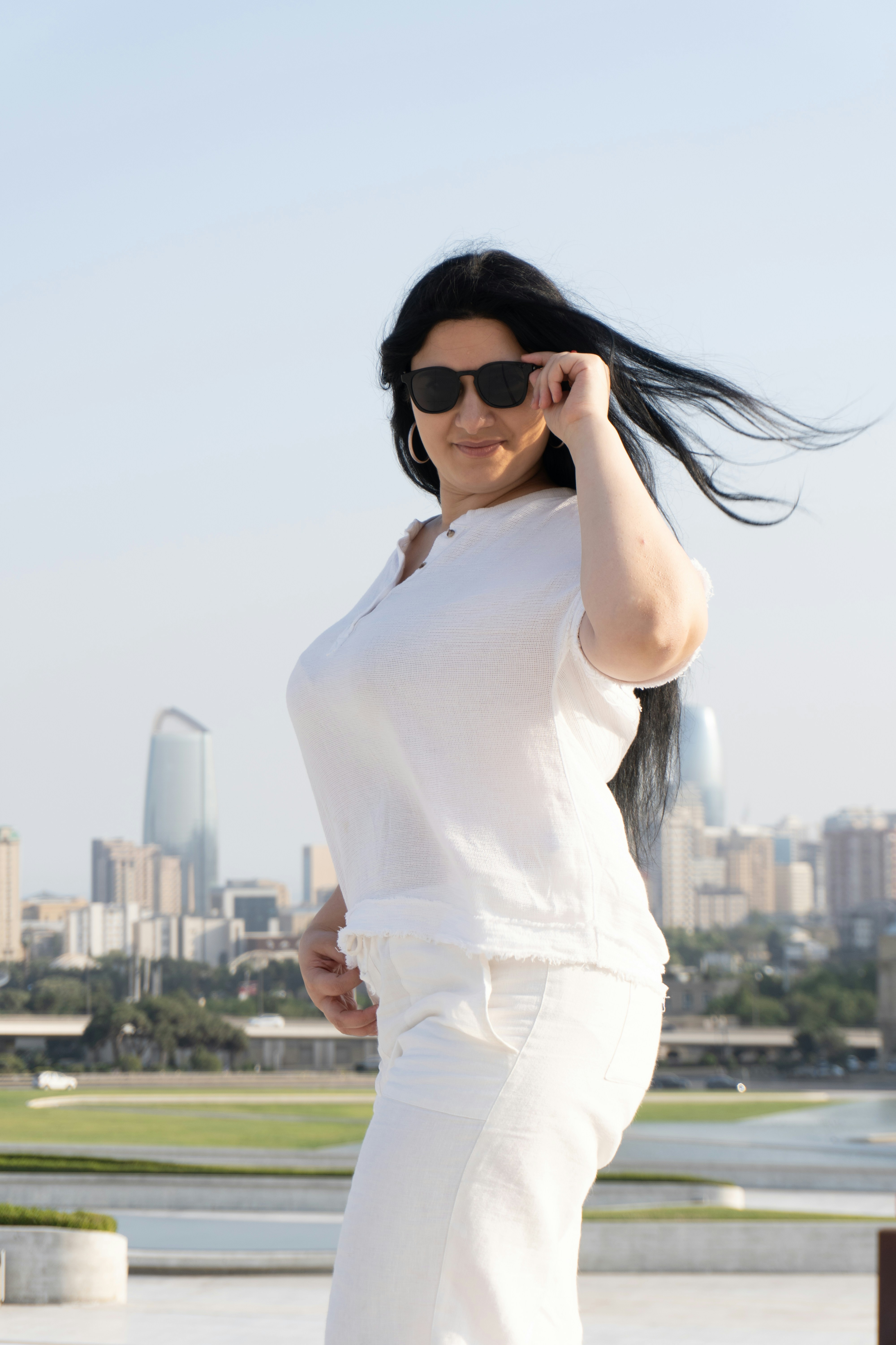 Sunlit Confidence: Portrait in White with City Backdrop