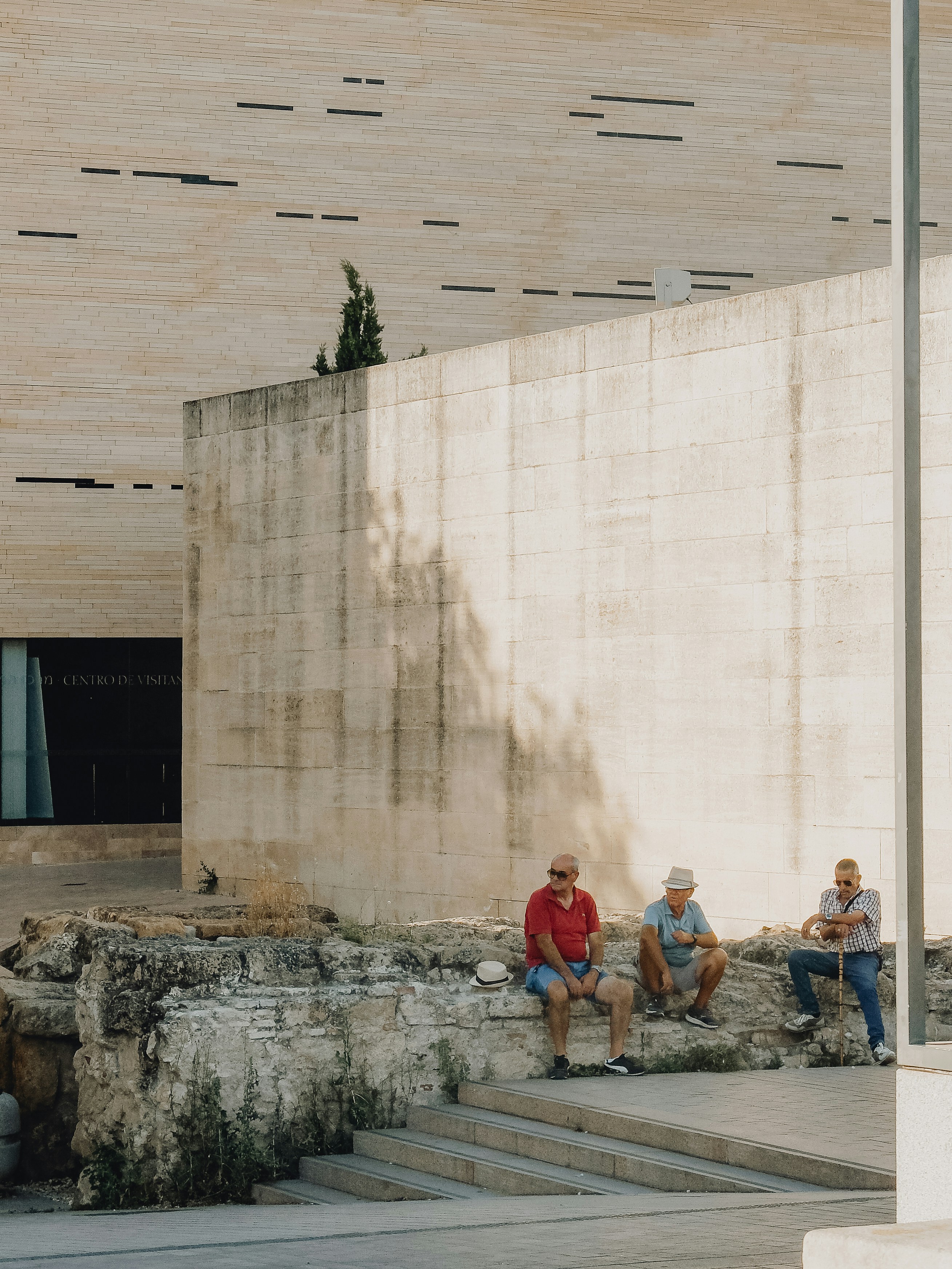 Three Seated Shadows: Quiet Conversation by a Modern Concrete Wall
