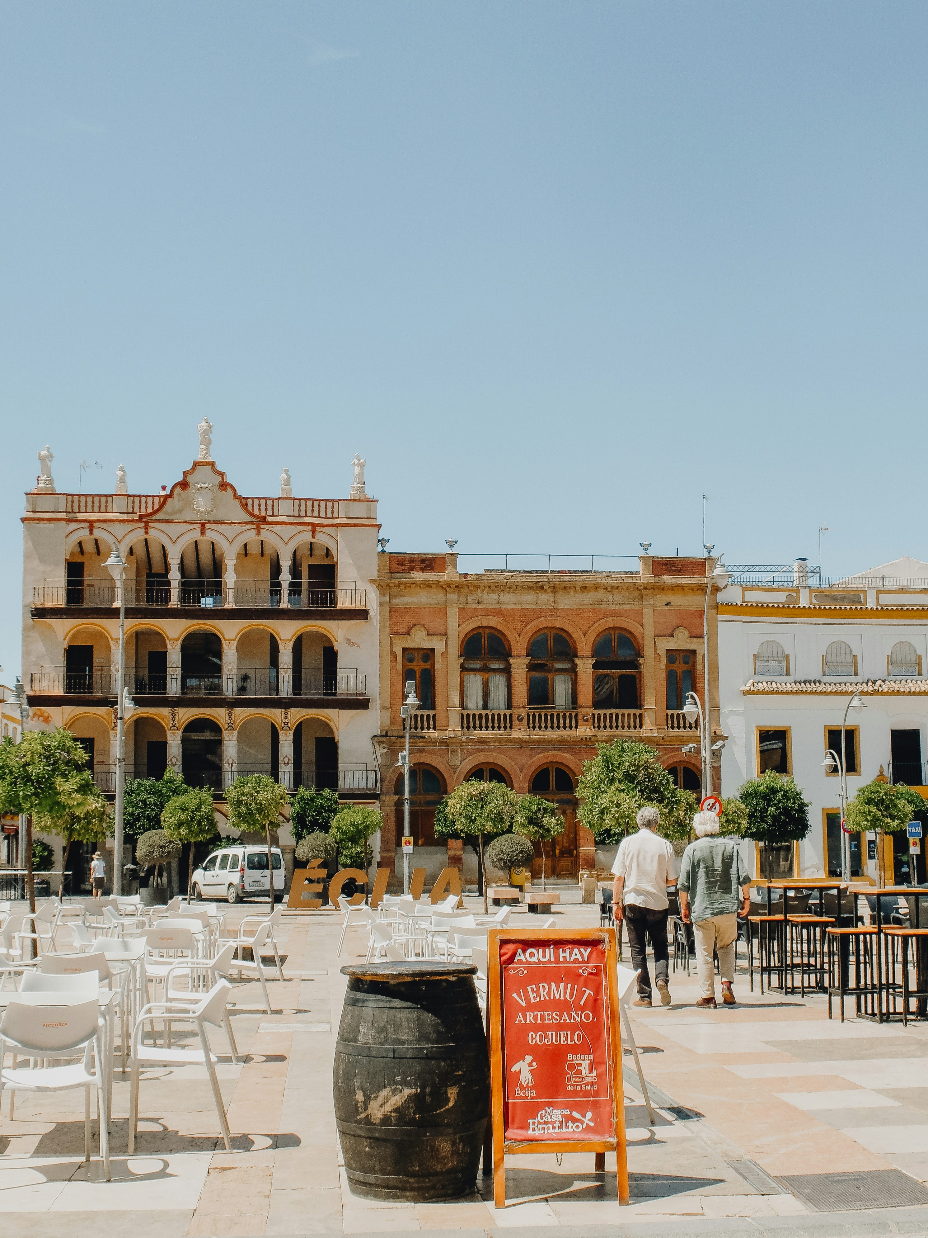 Sunlit Plaza with Arched Facades and Café Terrace